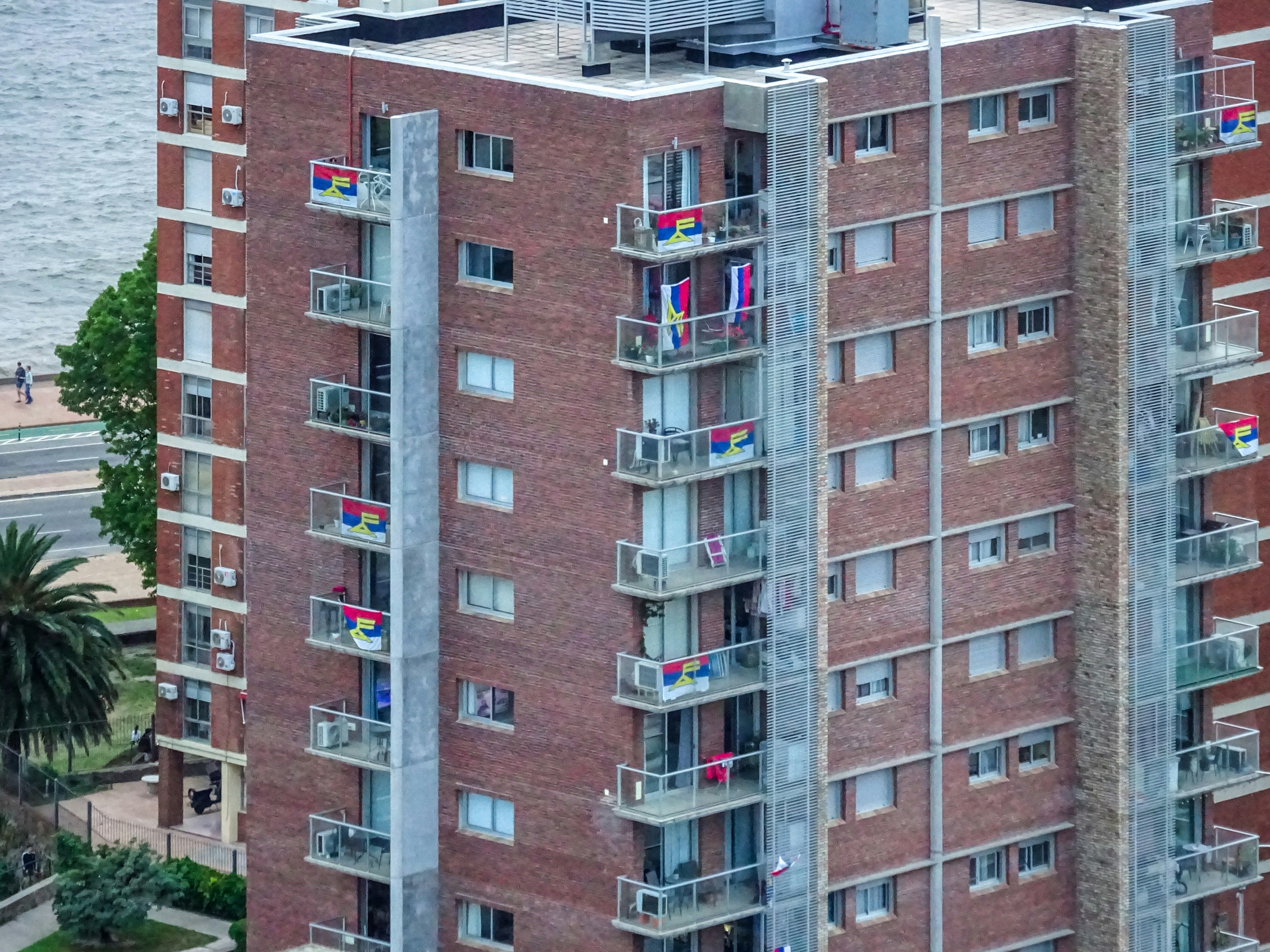 Tall brick apartment building with balconies and windows photo – Free ...