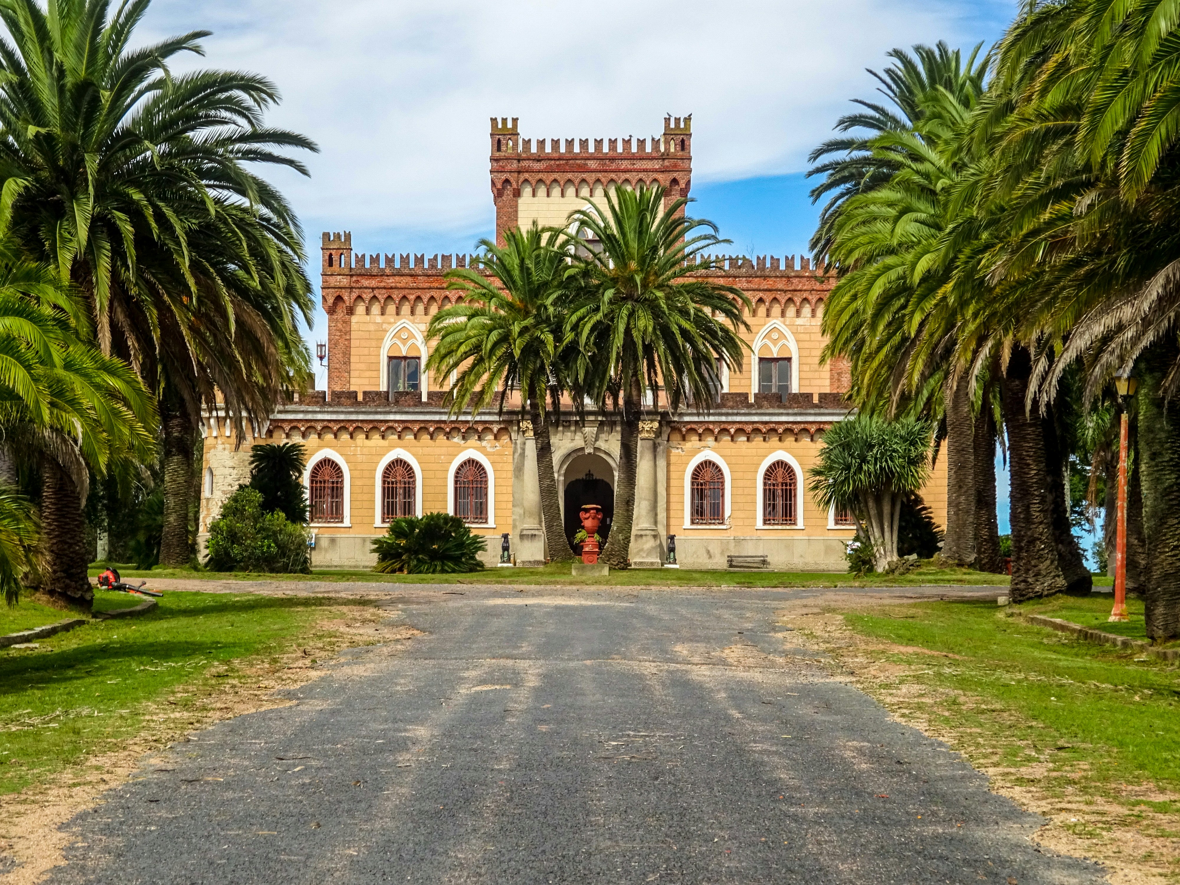 Ornate Gatehouse framed by palm-lined avenue