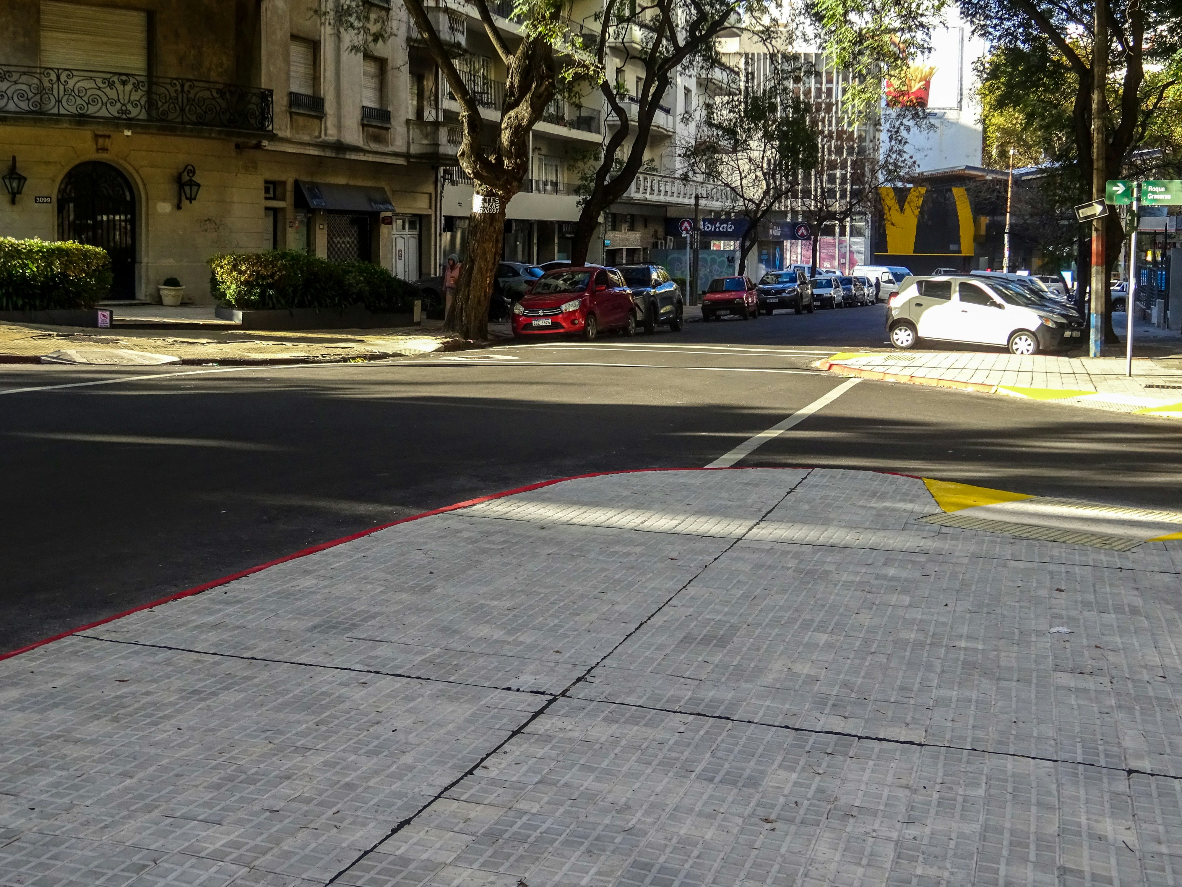 Urban Crosswalk Echo: Shadows, Cars, and a Quiet Facade