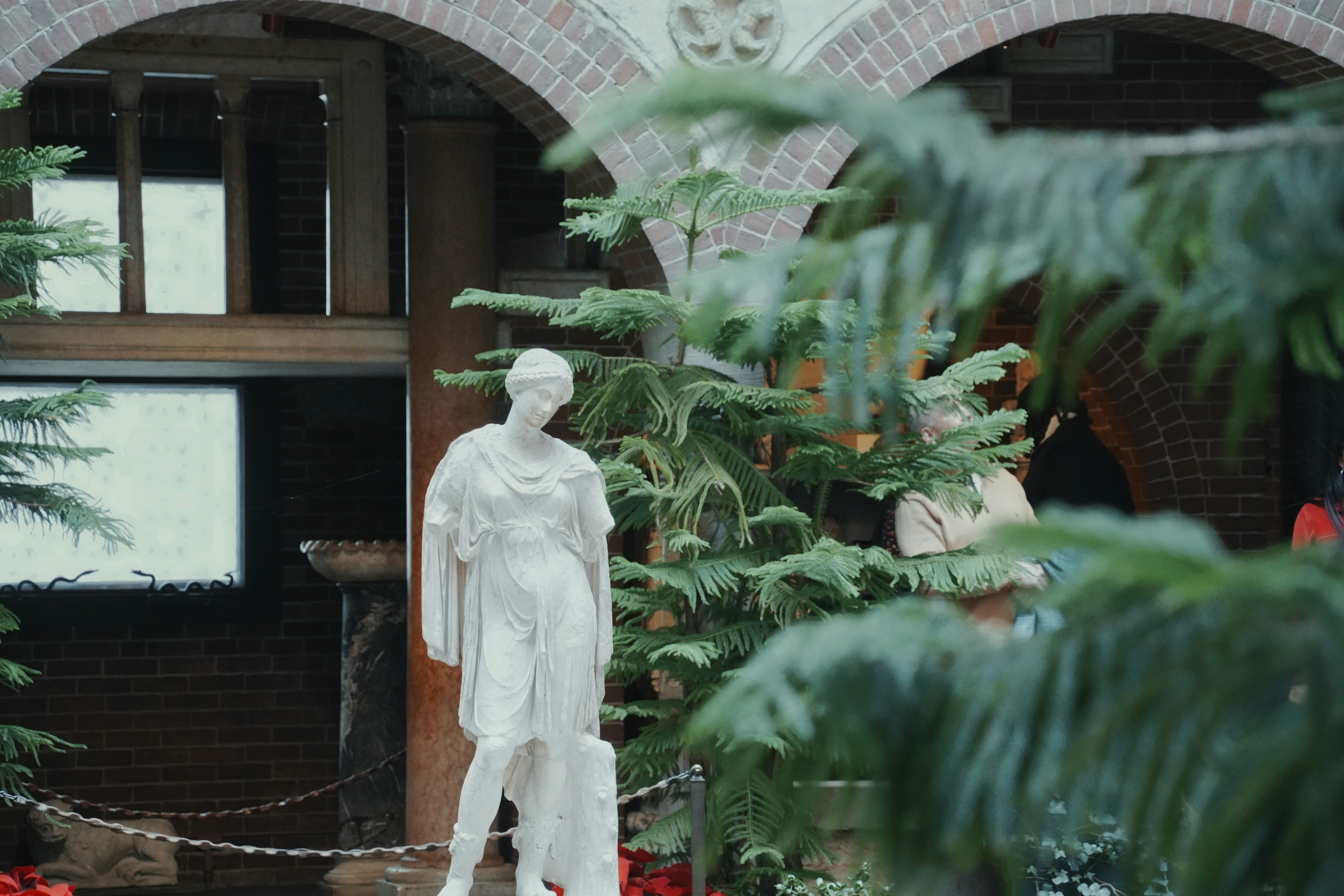 Statue in a shaded courtyard framed by lush greenery
