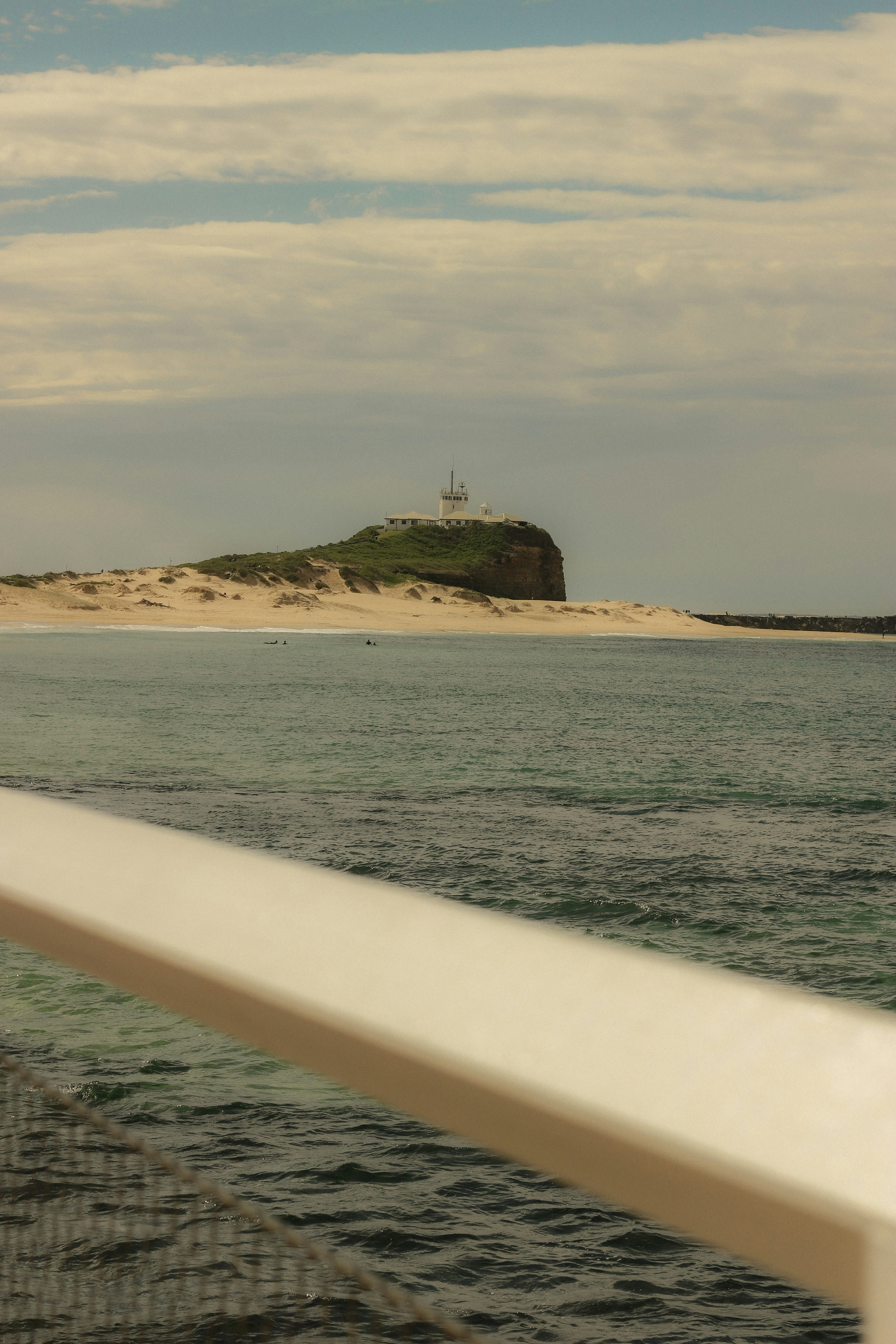Lighthouse on the Sea Cliff: Quiet Horizon Beyond a Painted Pier