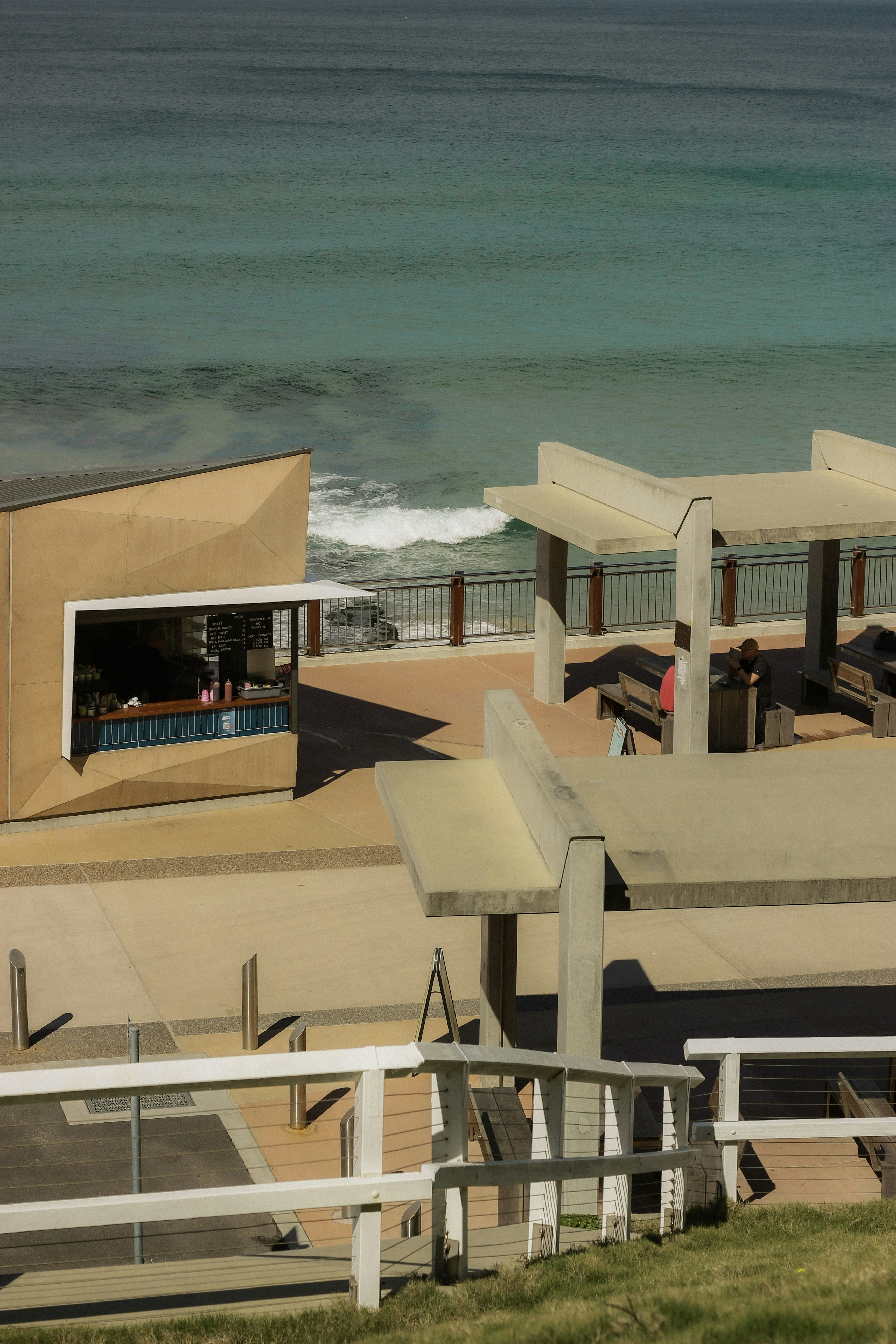 Coastal Terrace: Sunlit Pavilion Overlooking Turquoise Waves