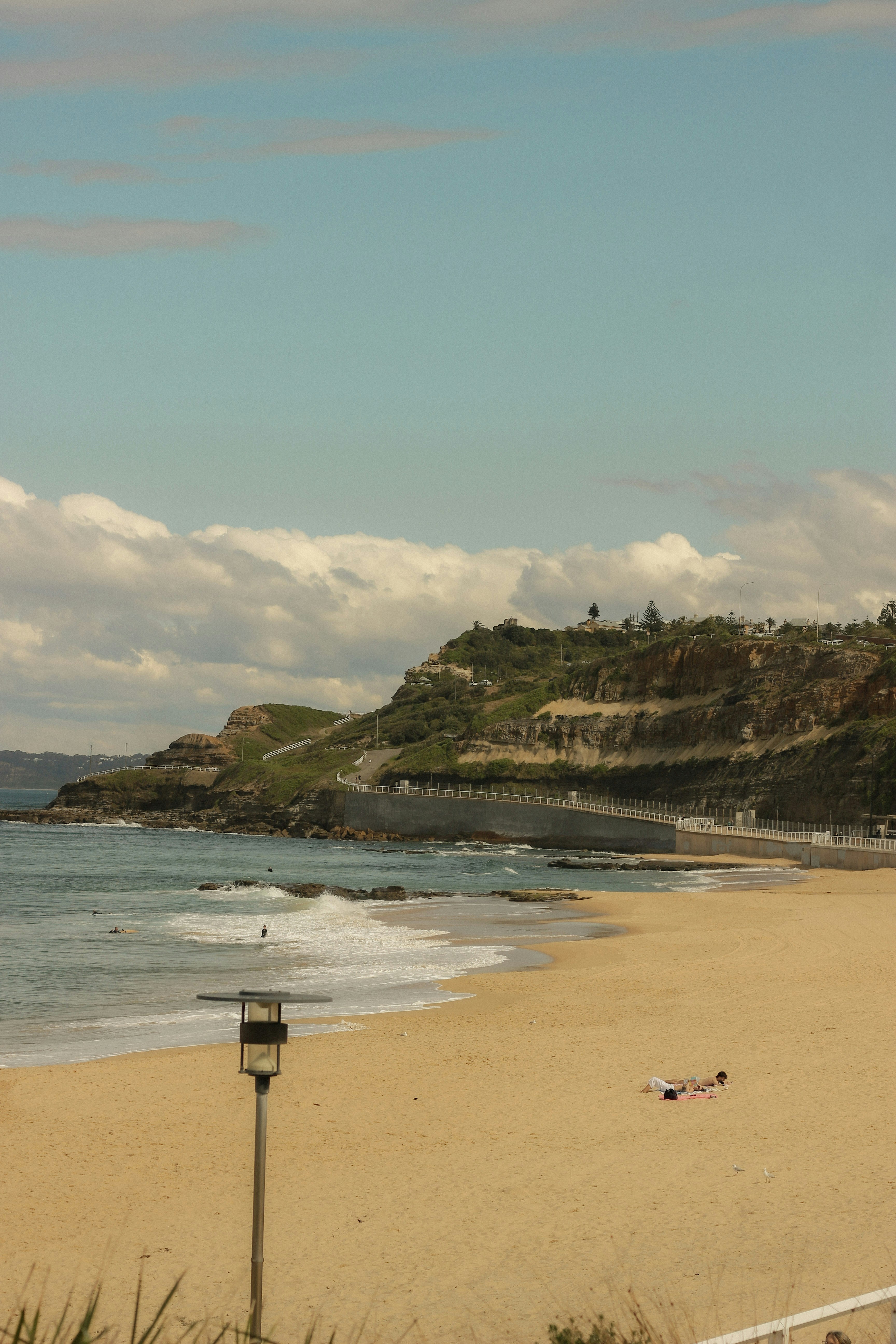 Coastal Terrace and Quiet Beachfront Under Sunlit Sky