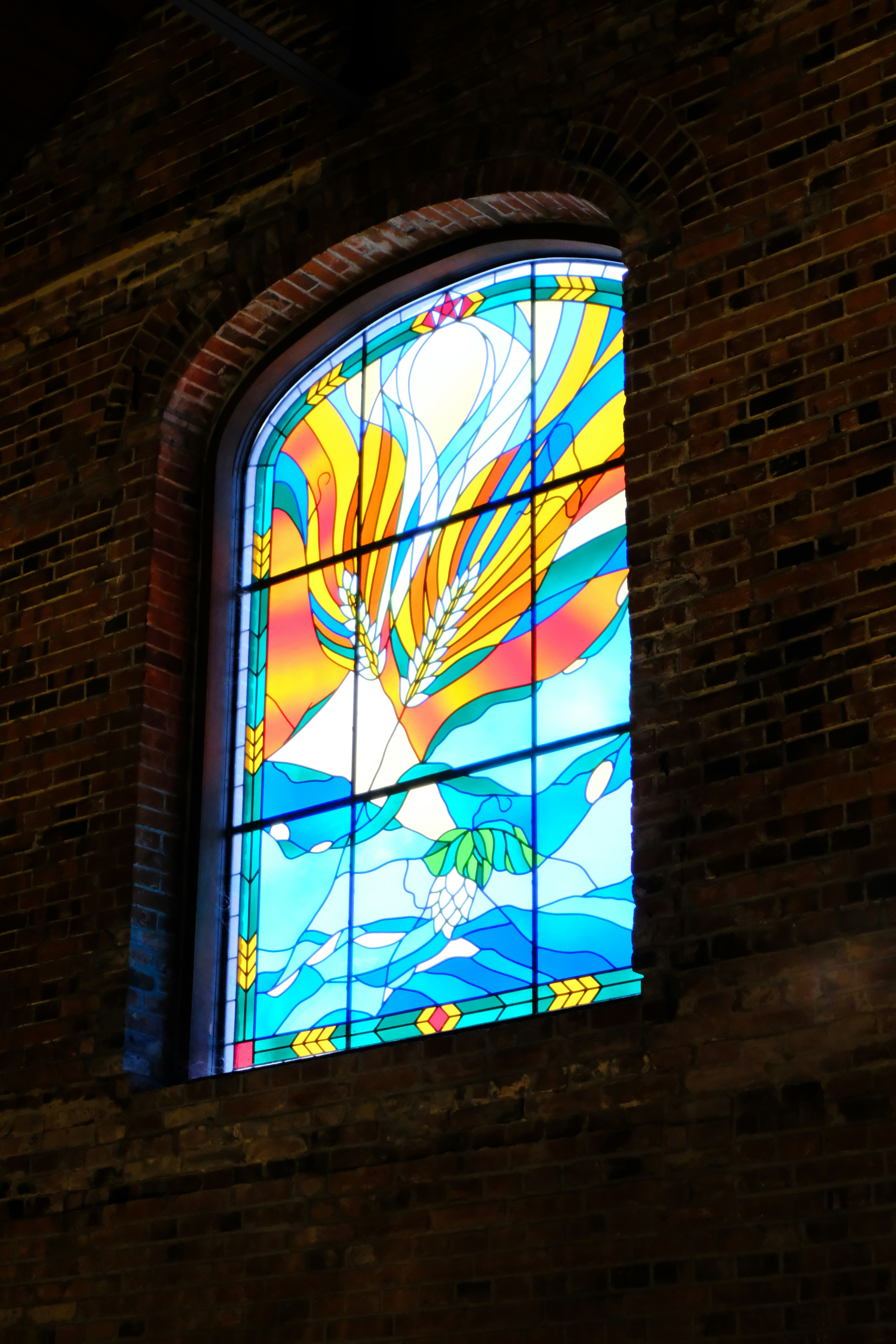 Vivid Stained Glass Window in Brick Arched Frame