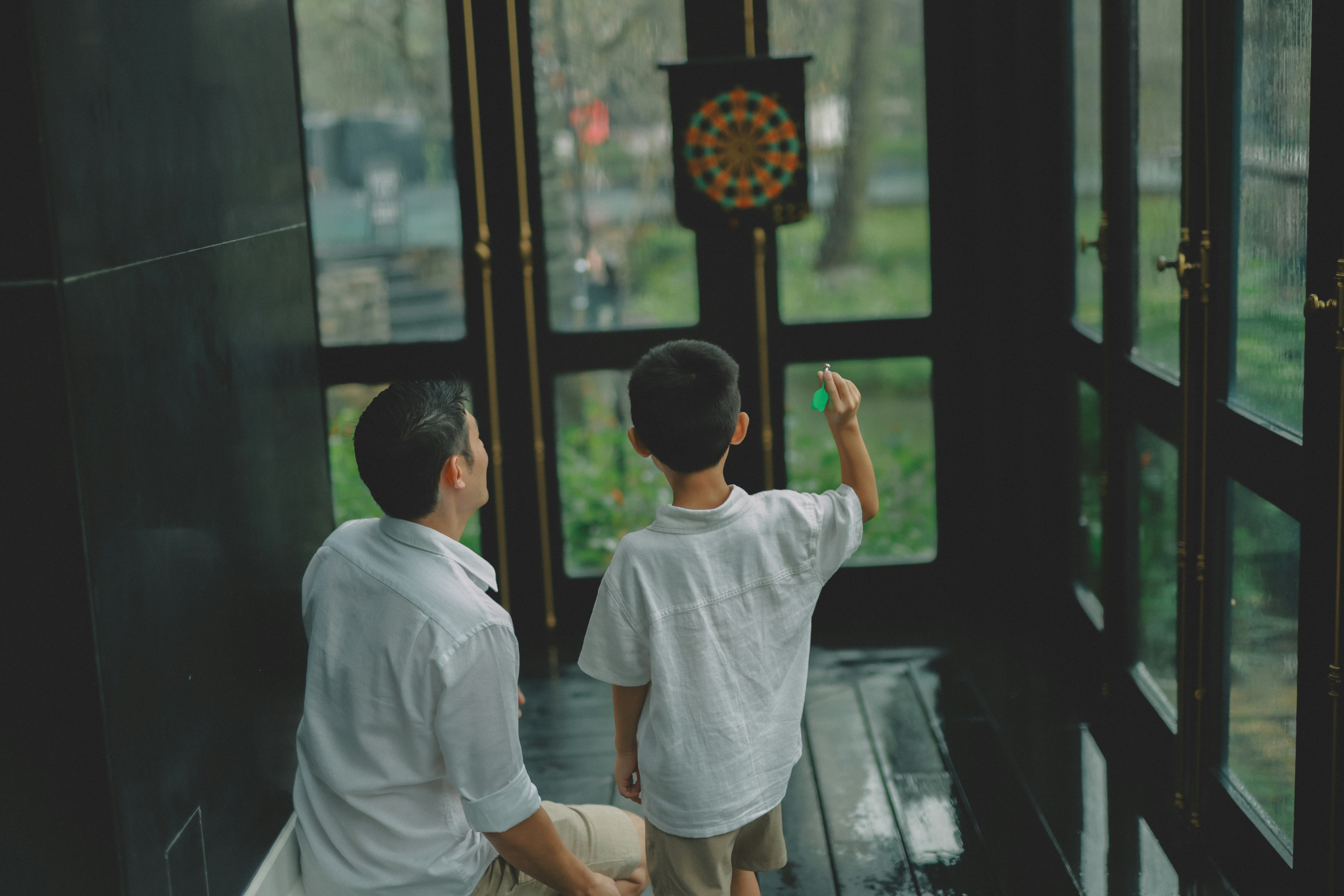 Dartboard Play: Two Boys in a Quiet Arcade