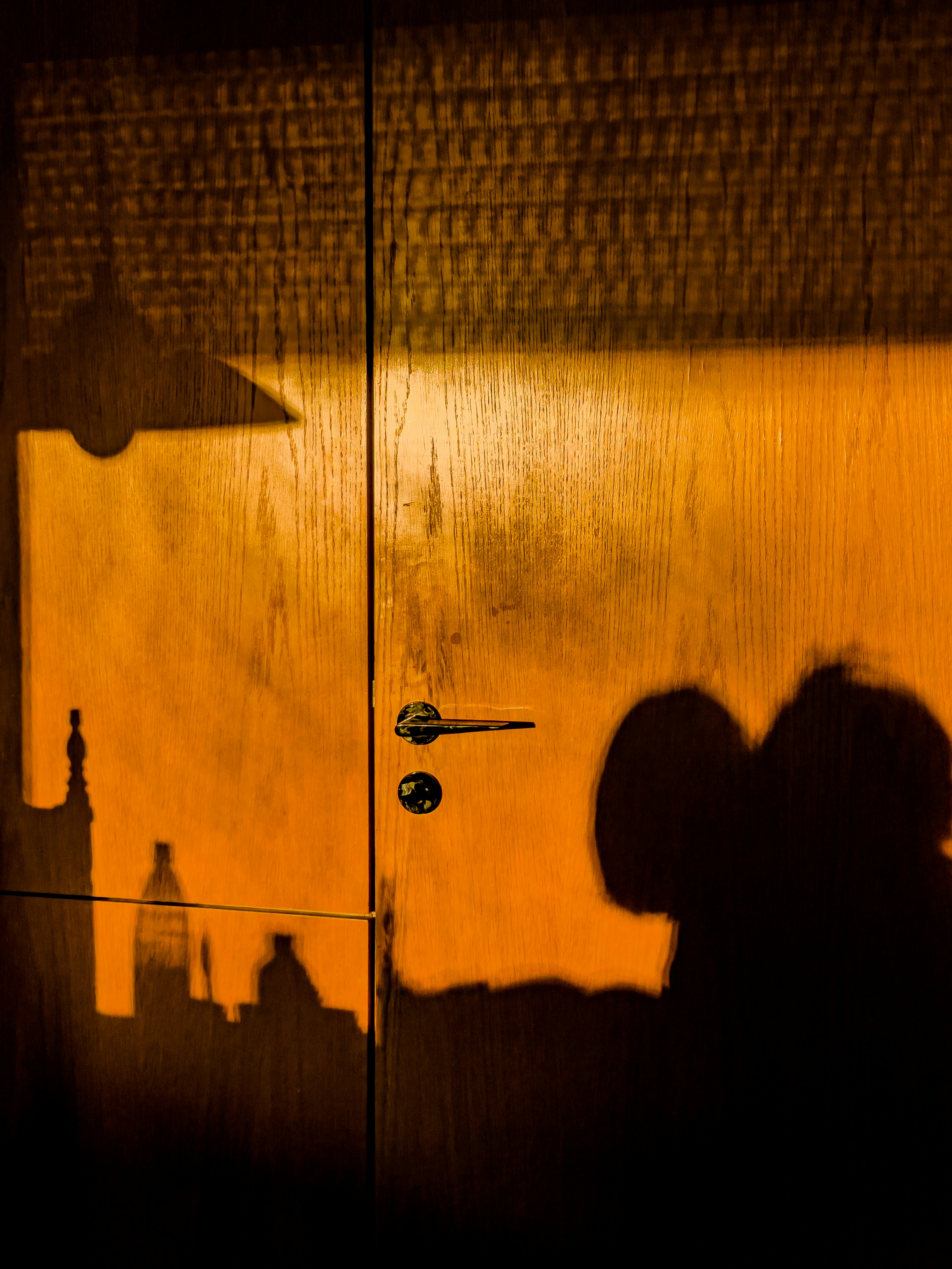 Shadowed Doorway: A Warm Glow and Hidden Figure