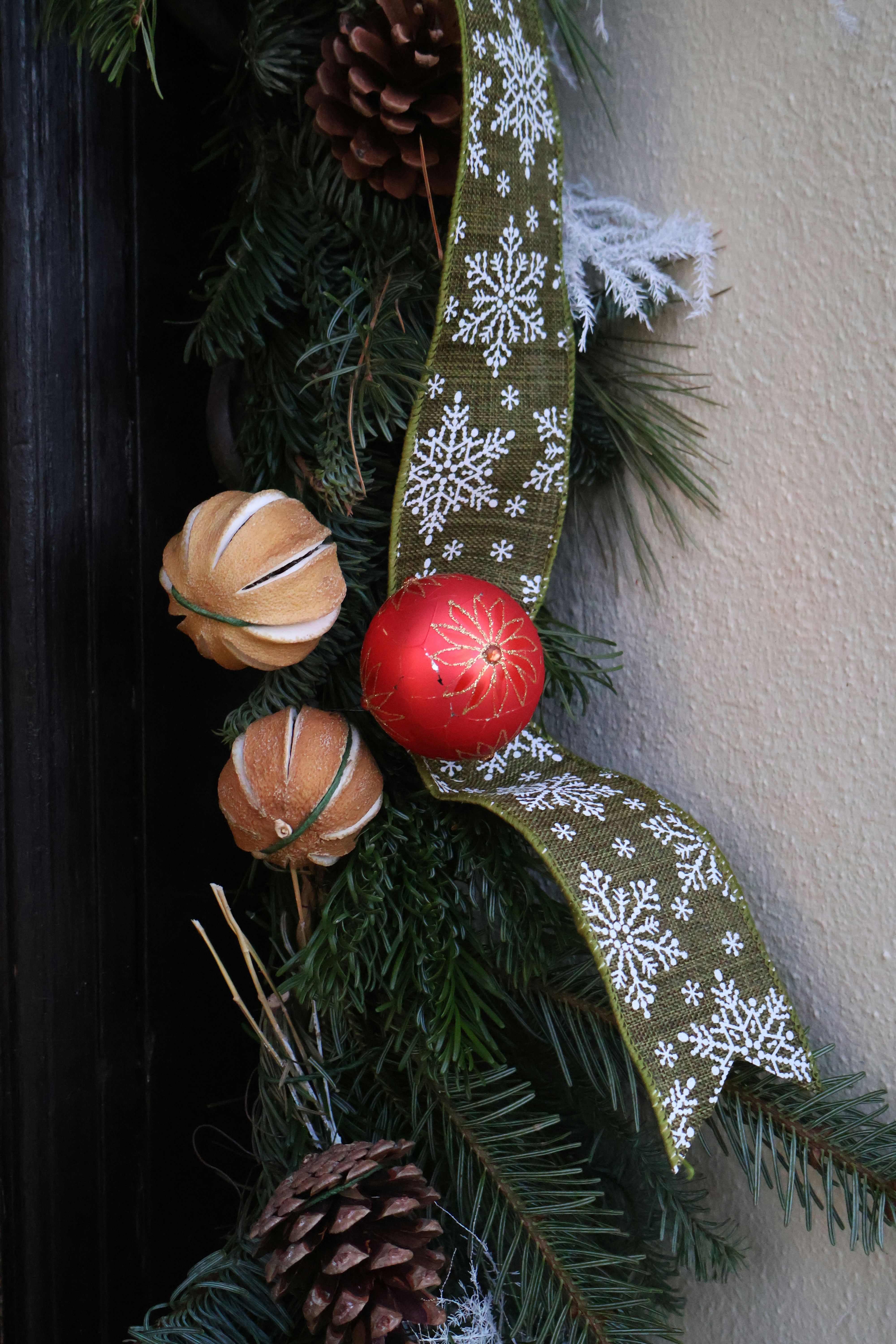 Festive Ribbon and Ornament Wreath Embraced by Pine Needles