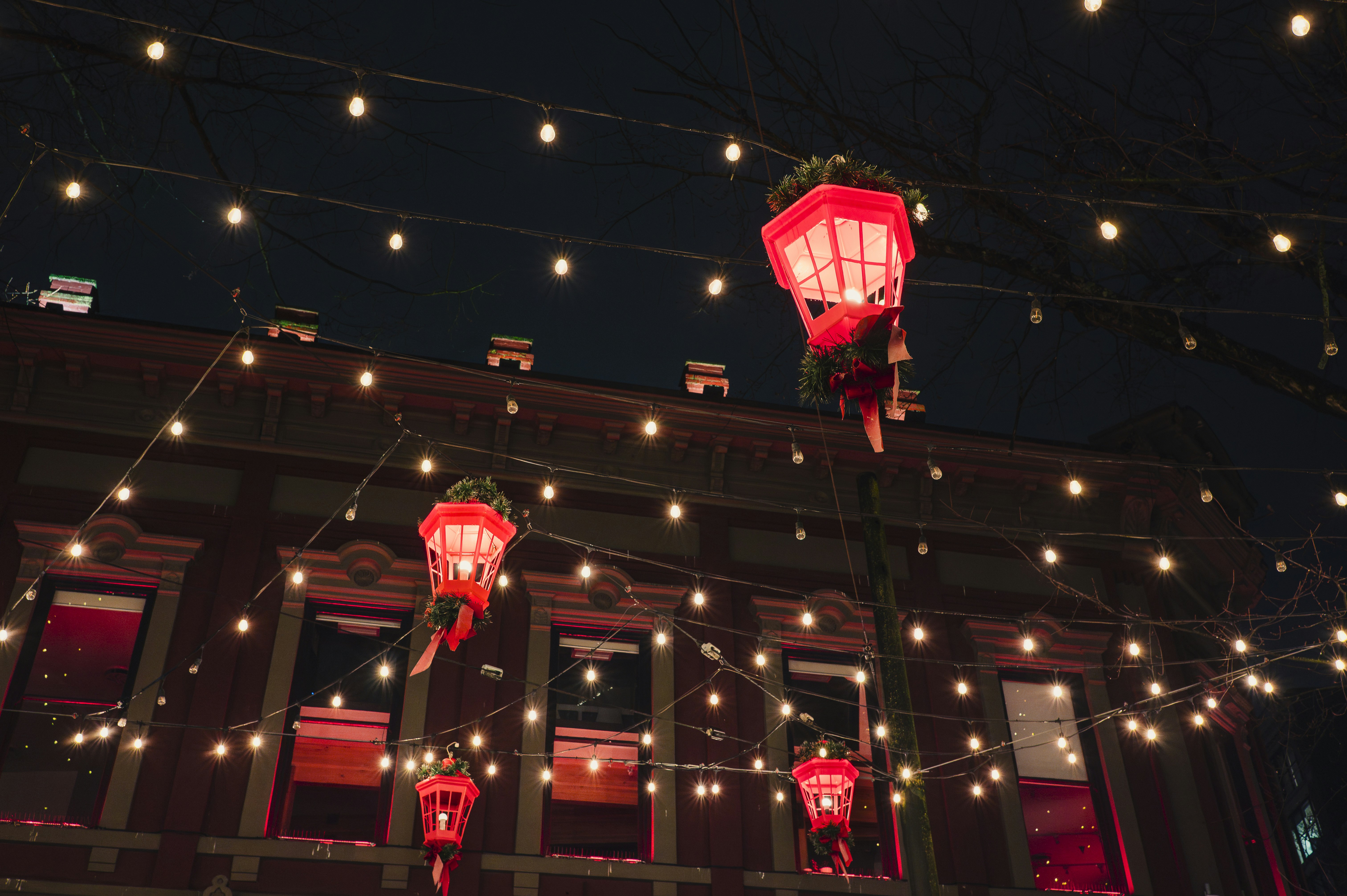 Christmas-decorated lanterns and string lights at night