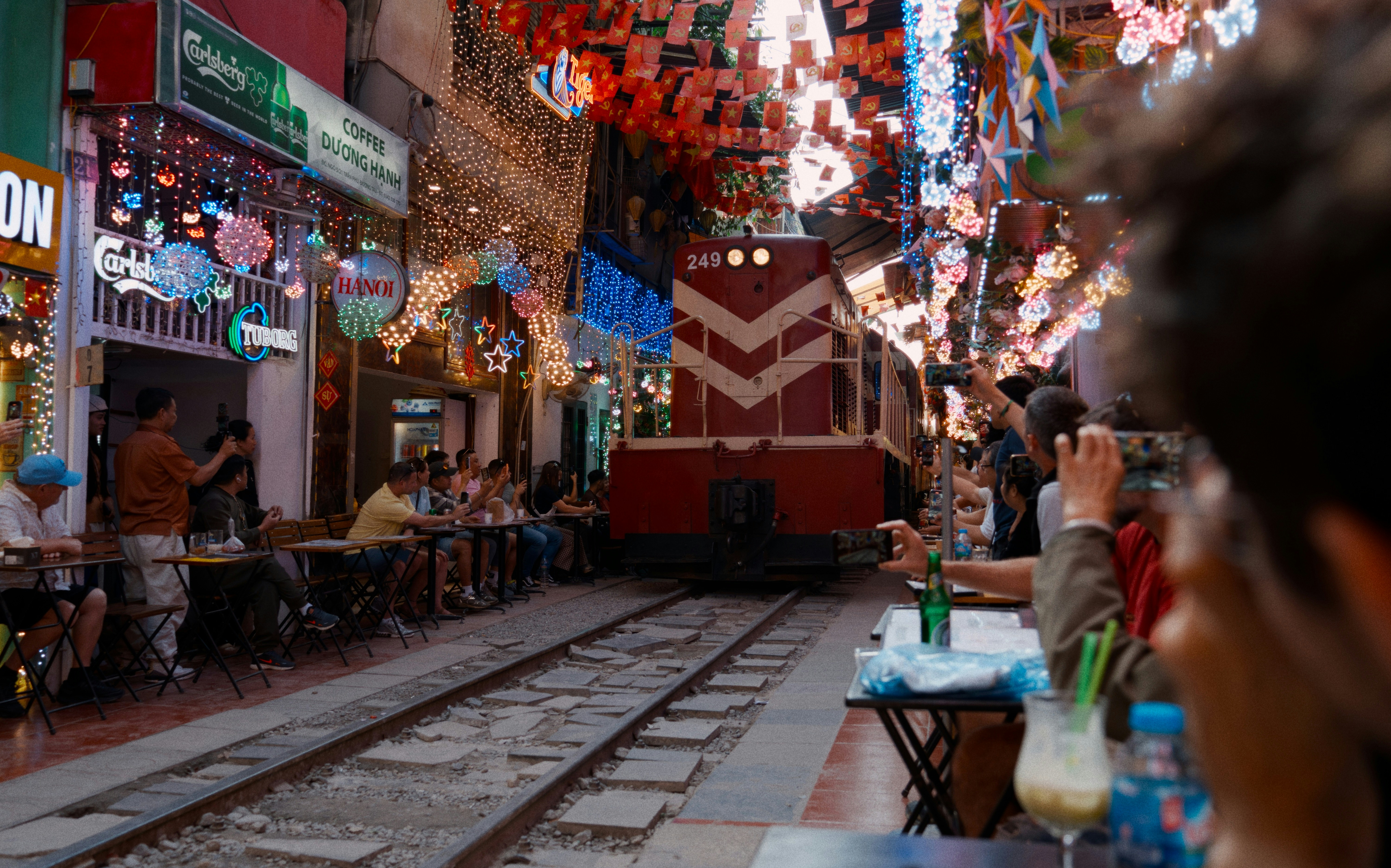 Train passing through a busy street cafe photo – Free Travel Image on ...