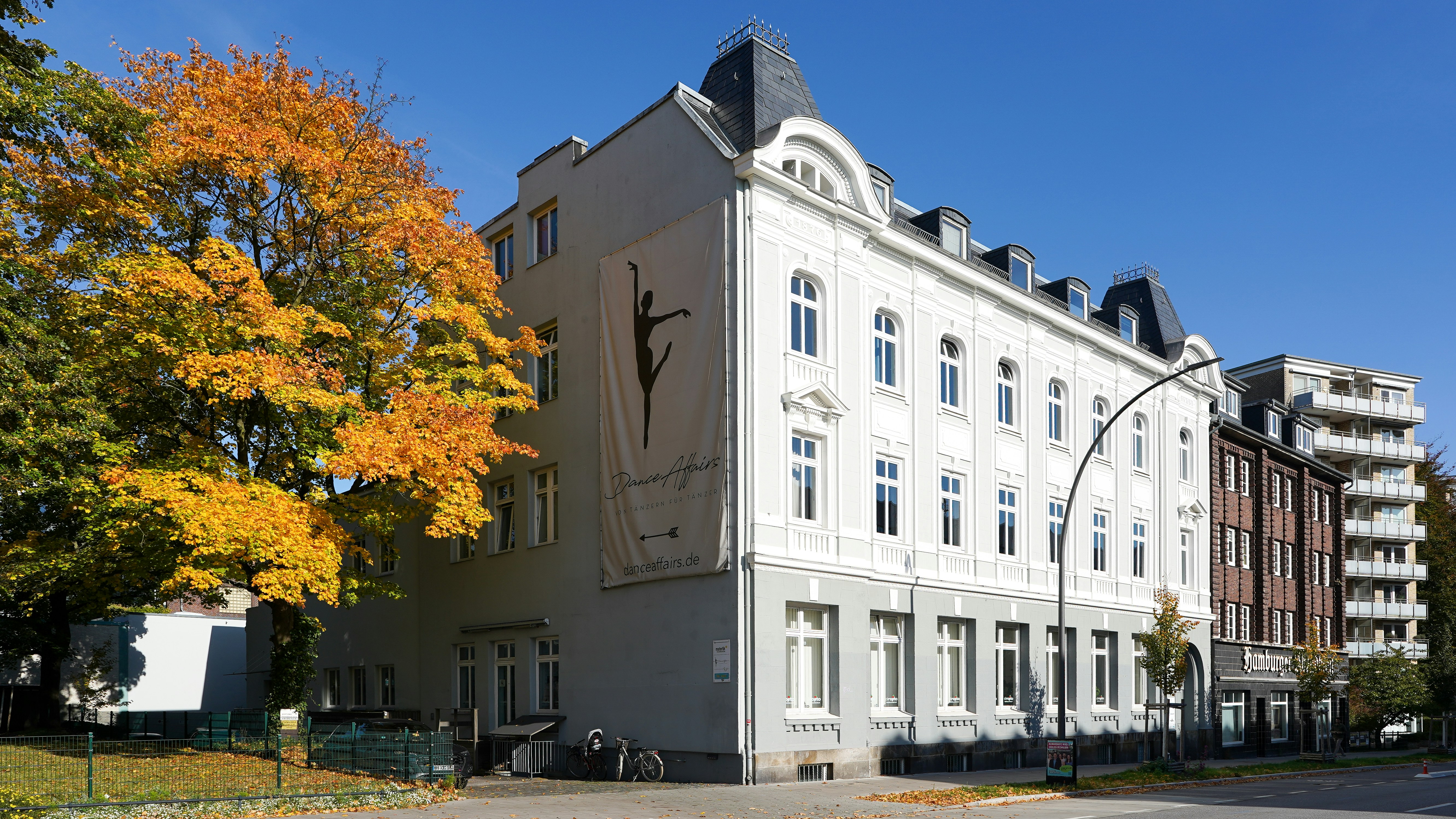 White building with autumn tree and mural. photo – Free Building Image ...