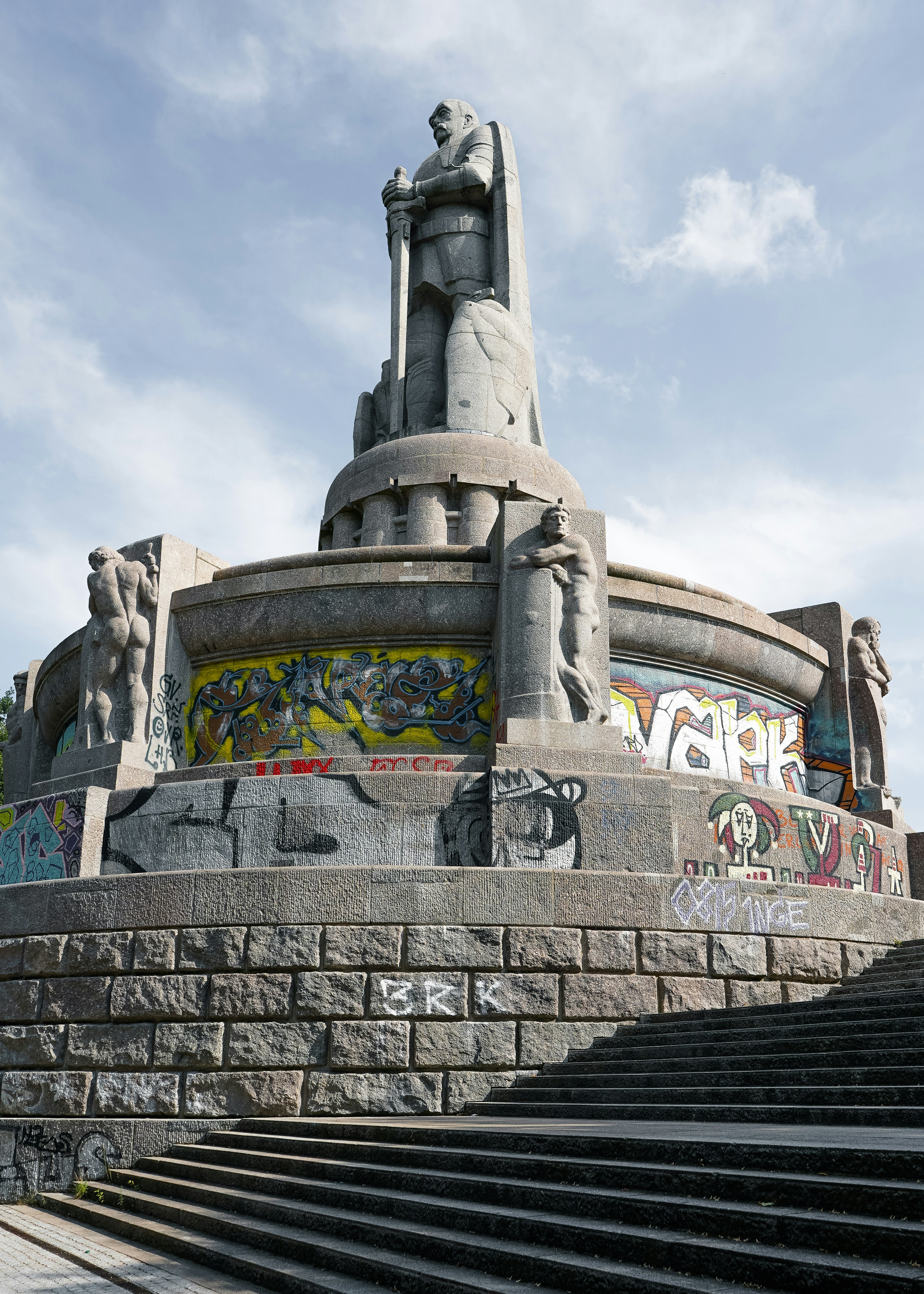 Monument Sentinel: A Graffiti-Bedazzled Pedestal Rising to a Marble Idol