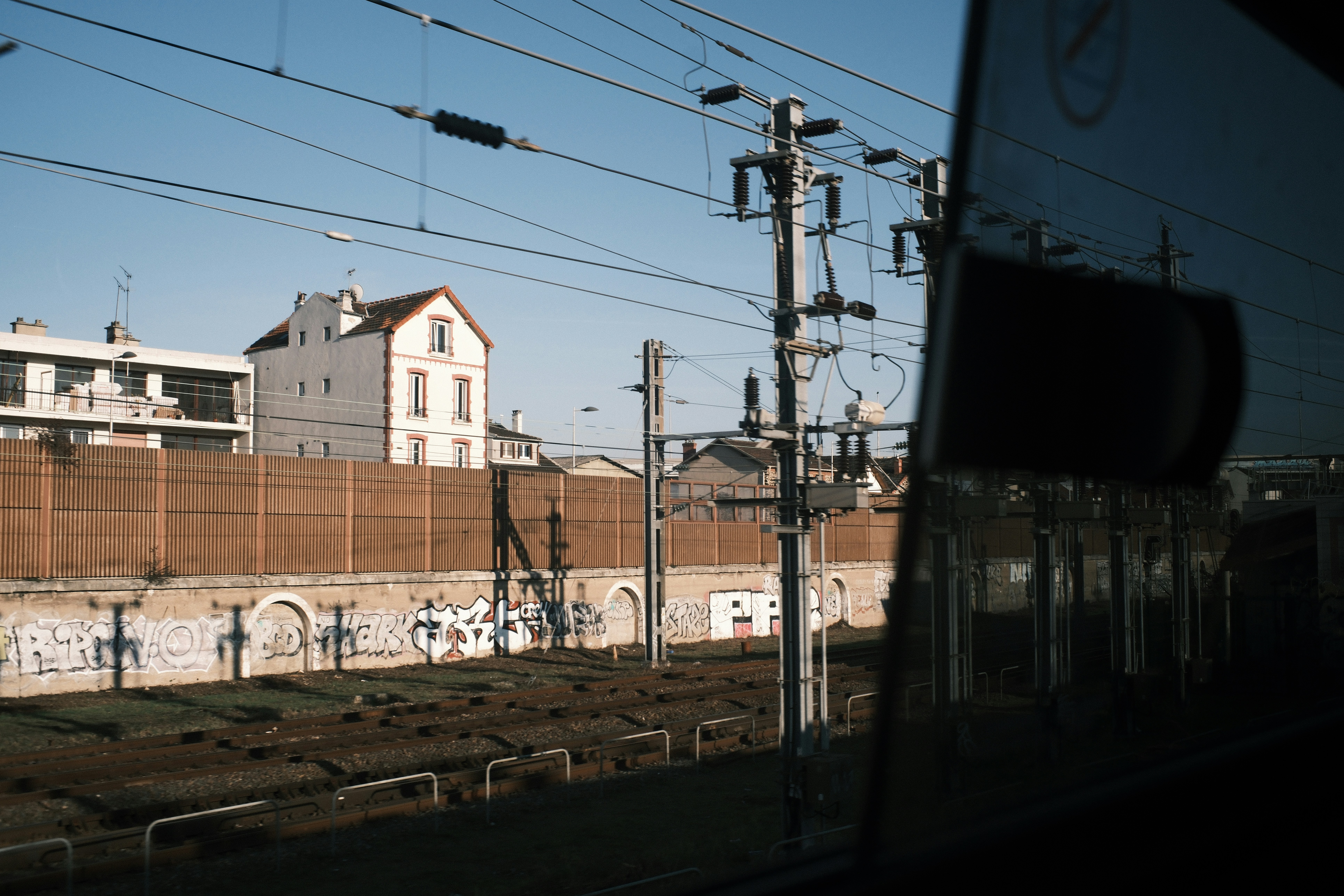 Tracks, Wires, and a Distant Facade