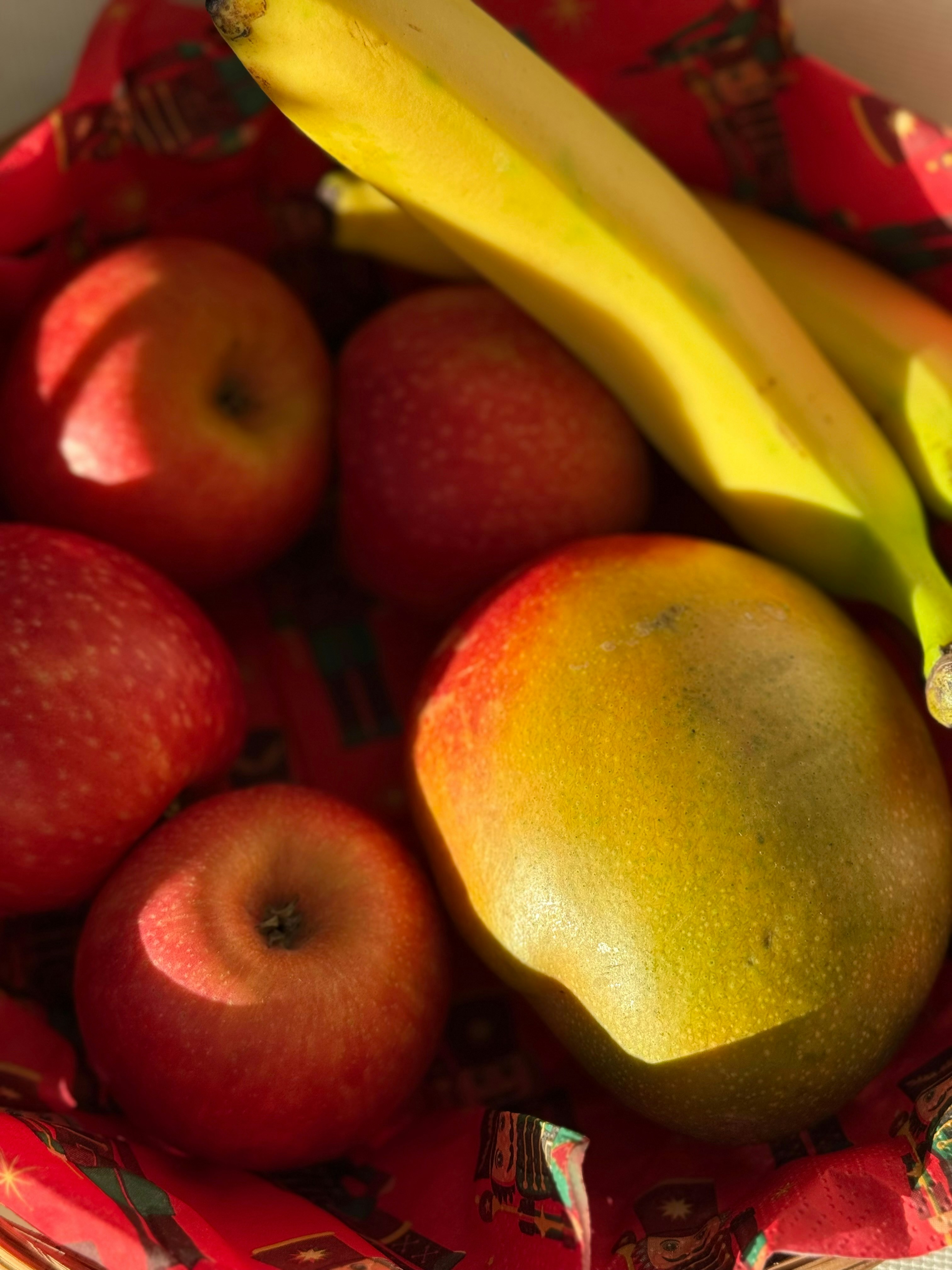 Fruit basket with Pink Lady apples, a mango, and bananas