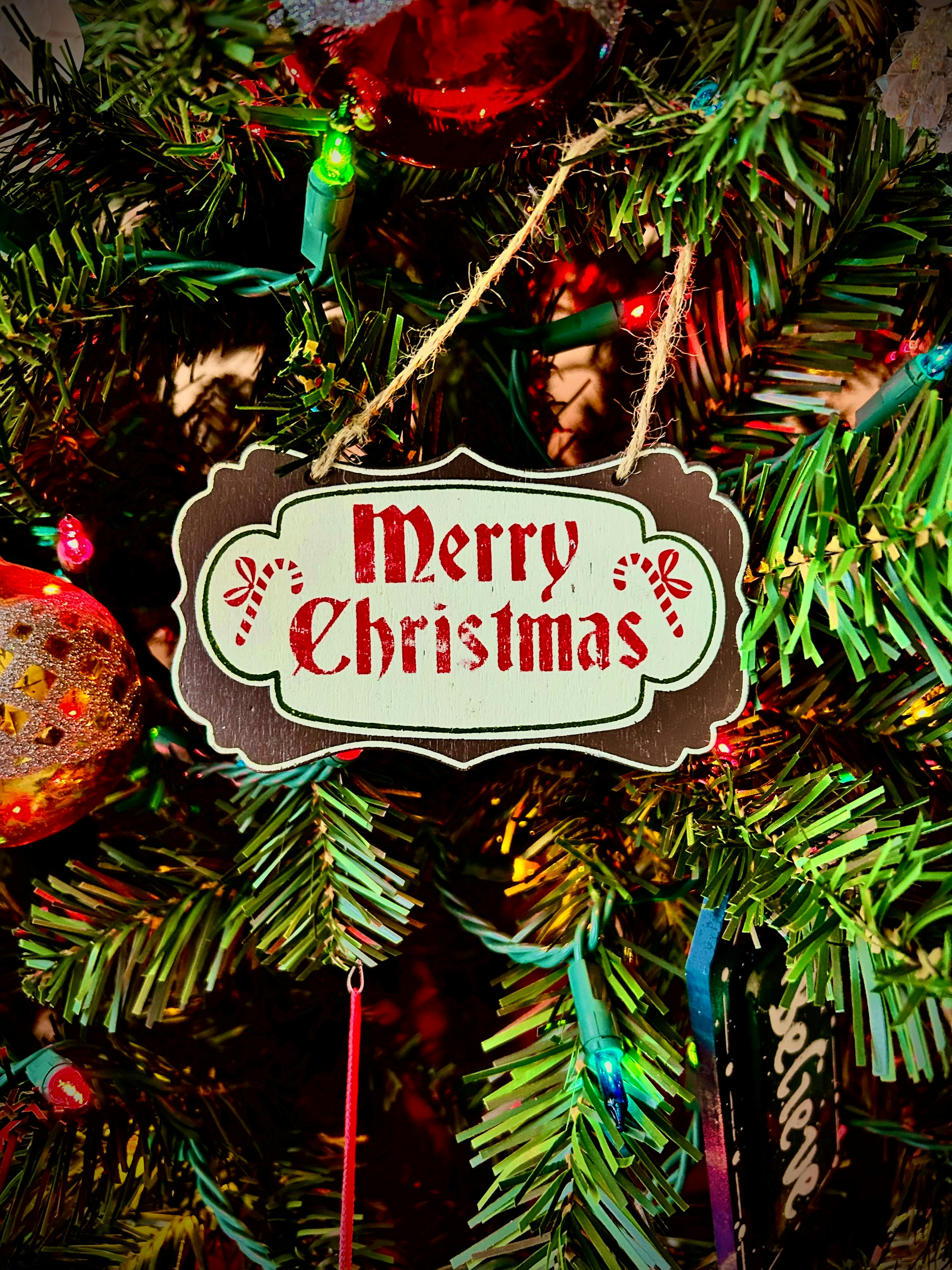 Merry Christmas Sign Amid Luminous Christmas Greens