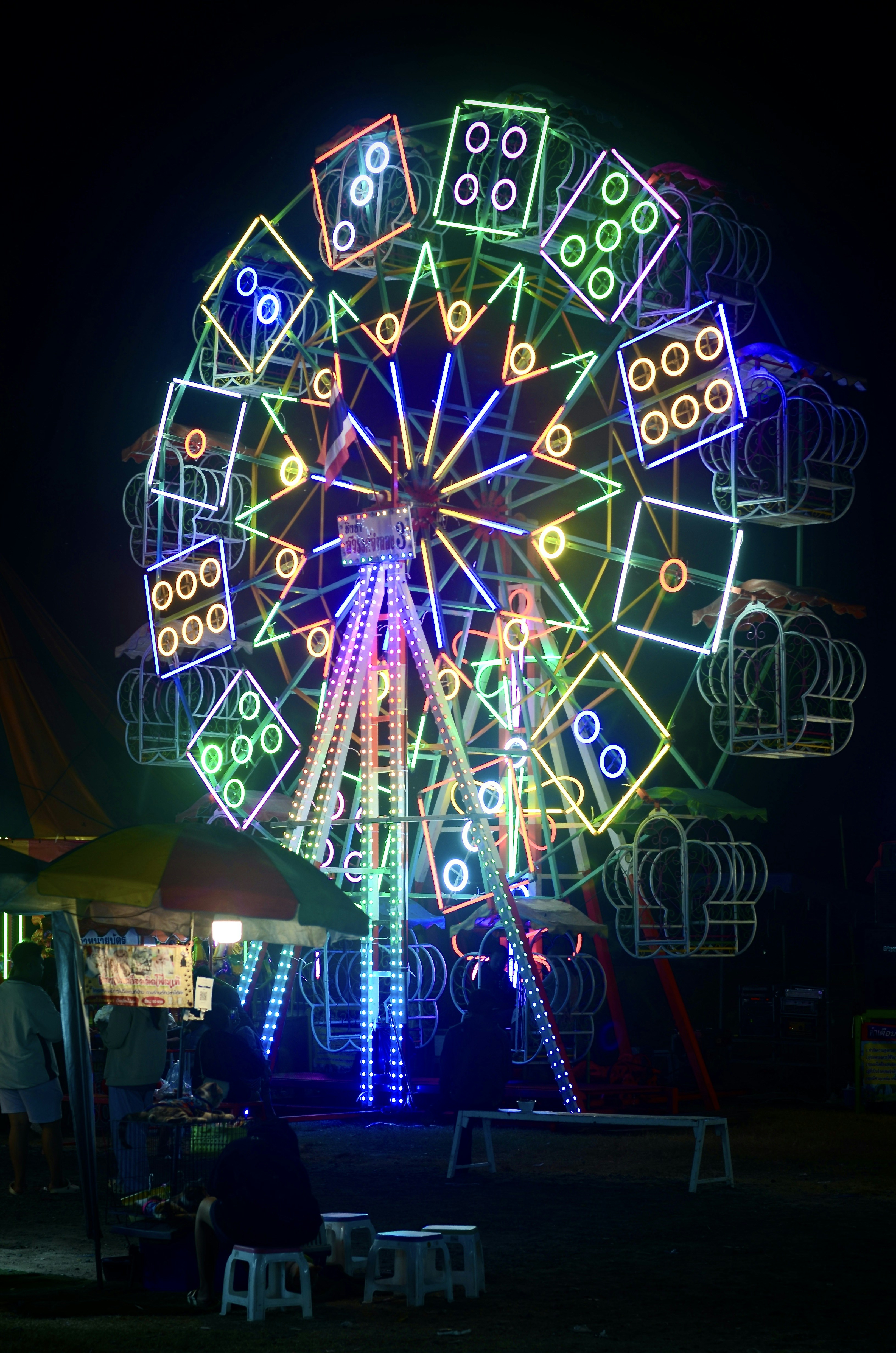 Neon Wheel of Light: Nighttime Ferris Ride Illuminates the Carnival