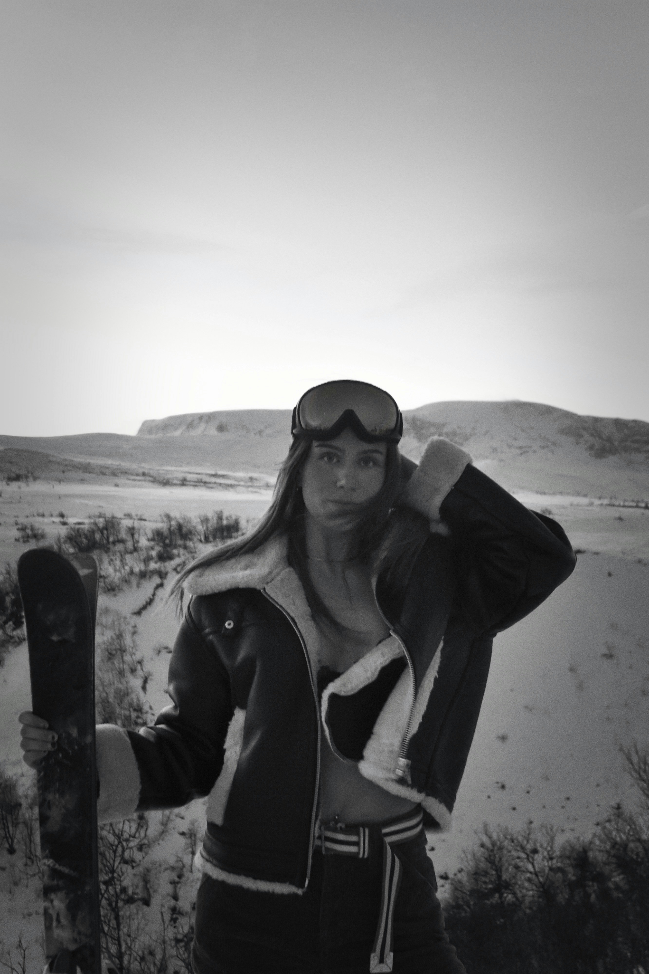 Snowbound Confidence: A snowboarder-turned-survivor stares toward the horizon
