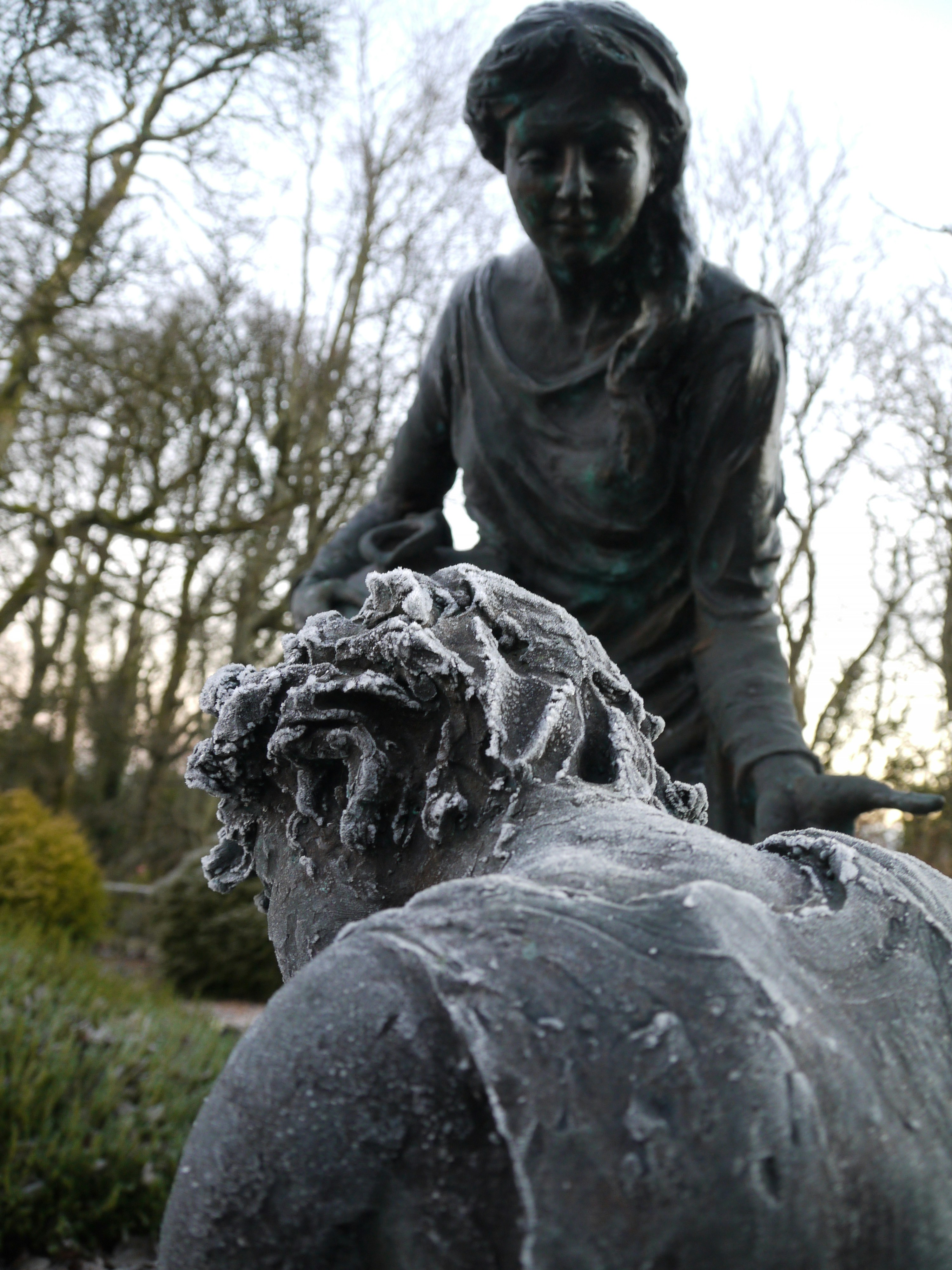 Frozen Reverie: A Statue’s Silent Gaze Over the Frosted Figure