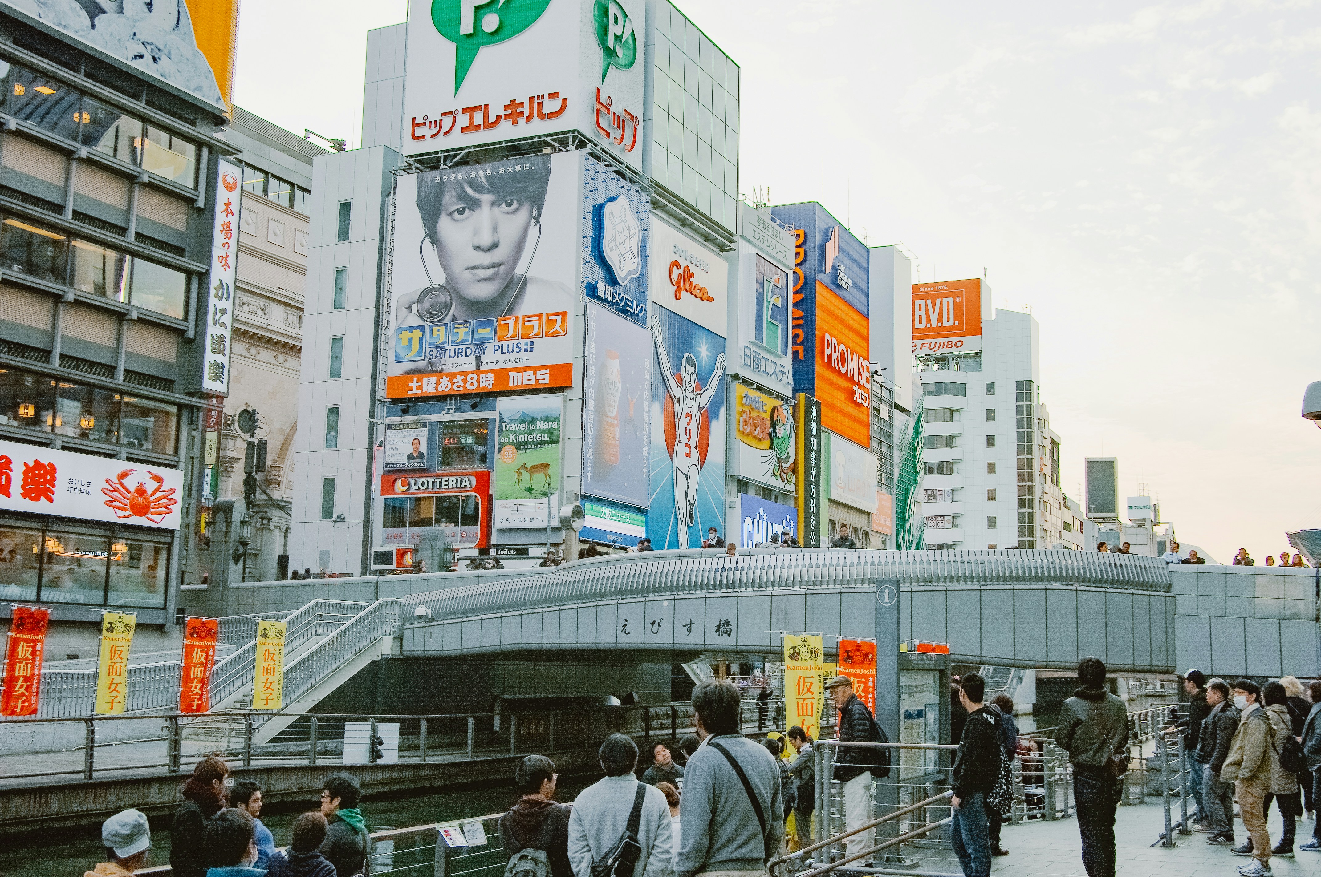 Billboards and Footsteps in a Neon-Heightened City Crossing