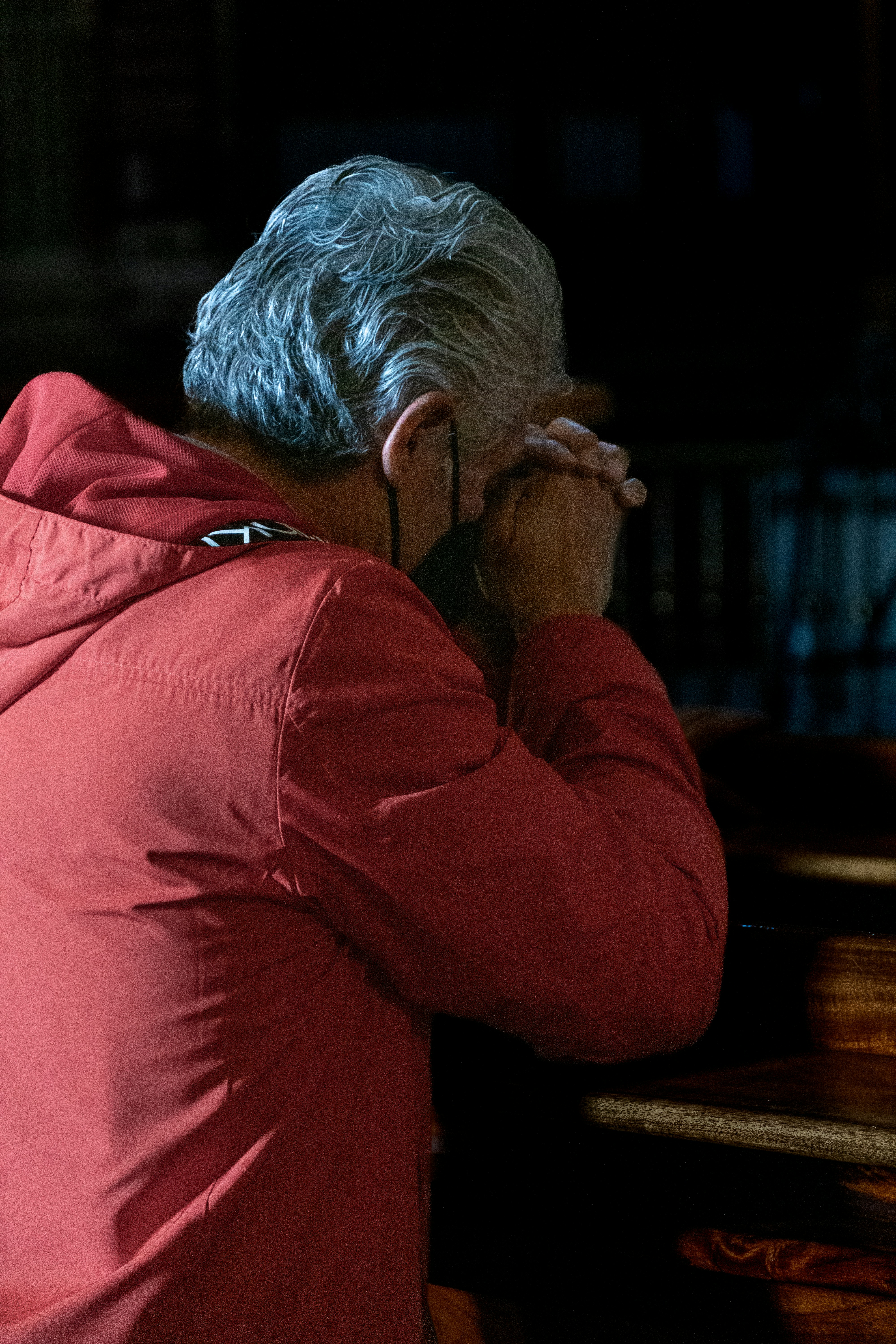 Quiet Prayer: A Red-Jacket Moment in Low Light