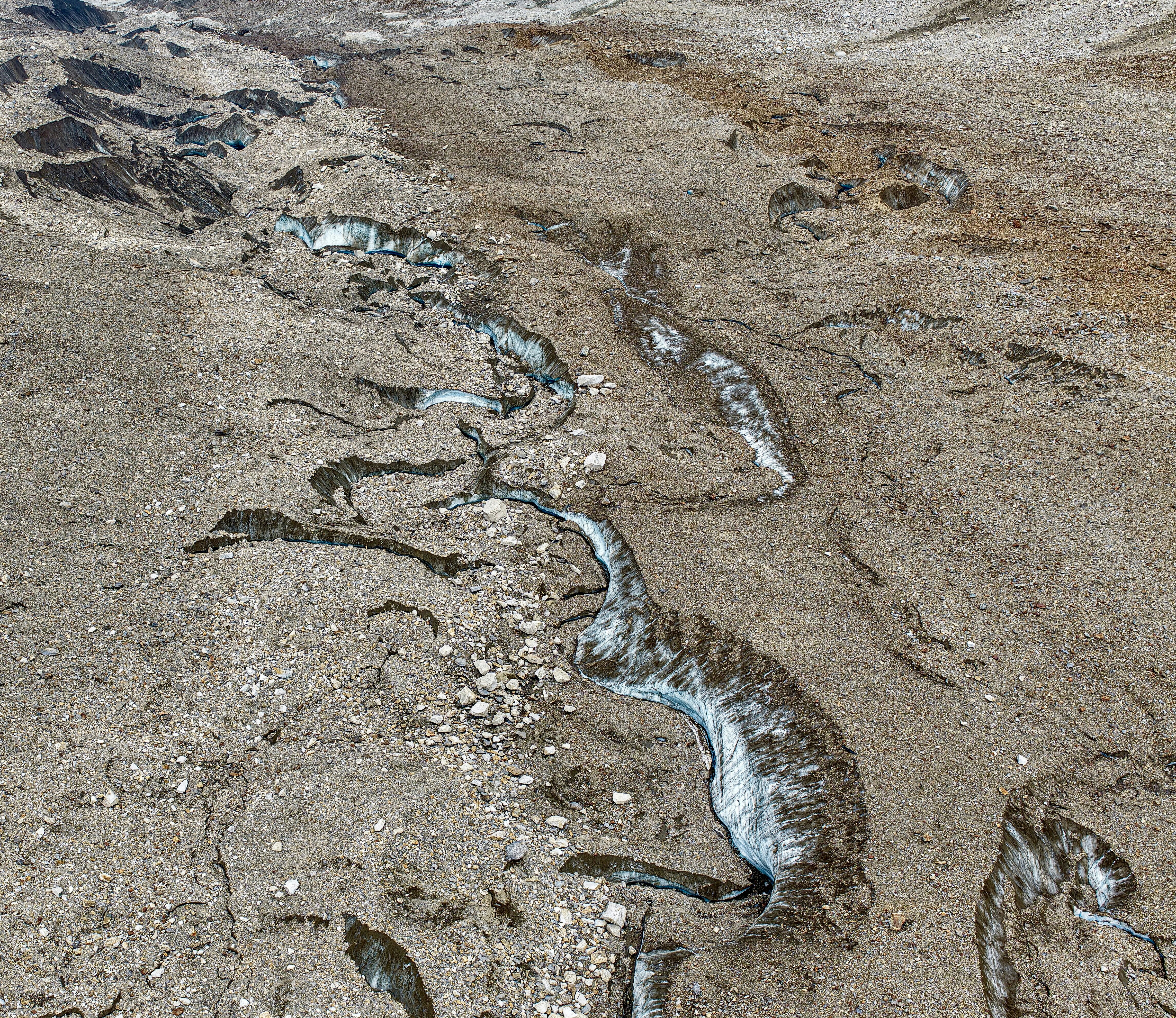 Cracked River of Ice: A Desert Shoreline Weaving Through Hollowed Terrains