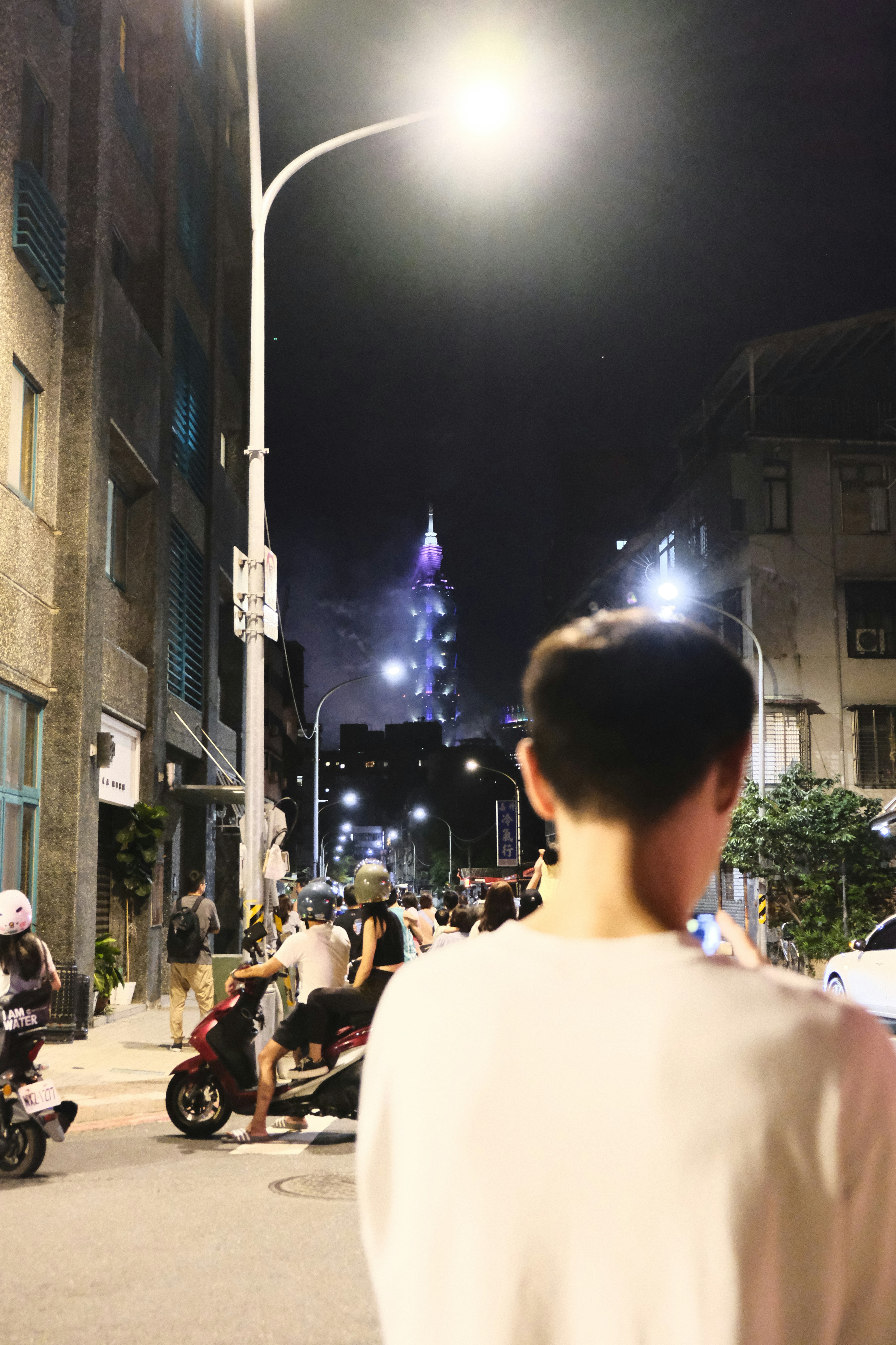 Neon Night Parade: A Street Portrait toward a Distant Tower