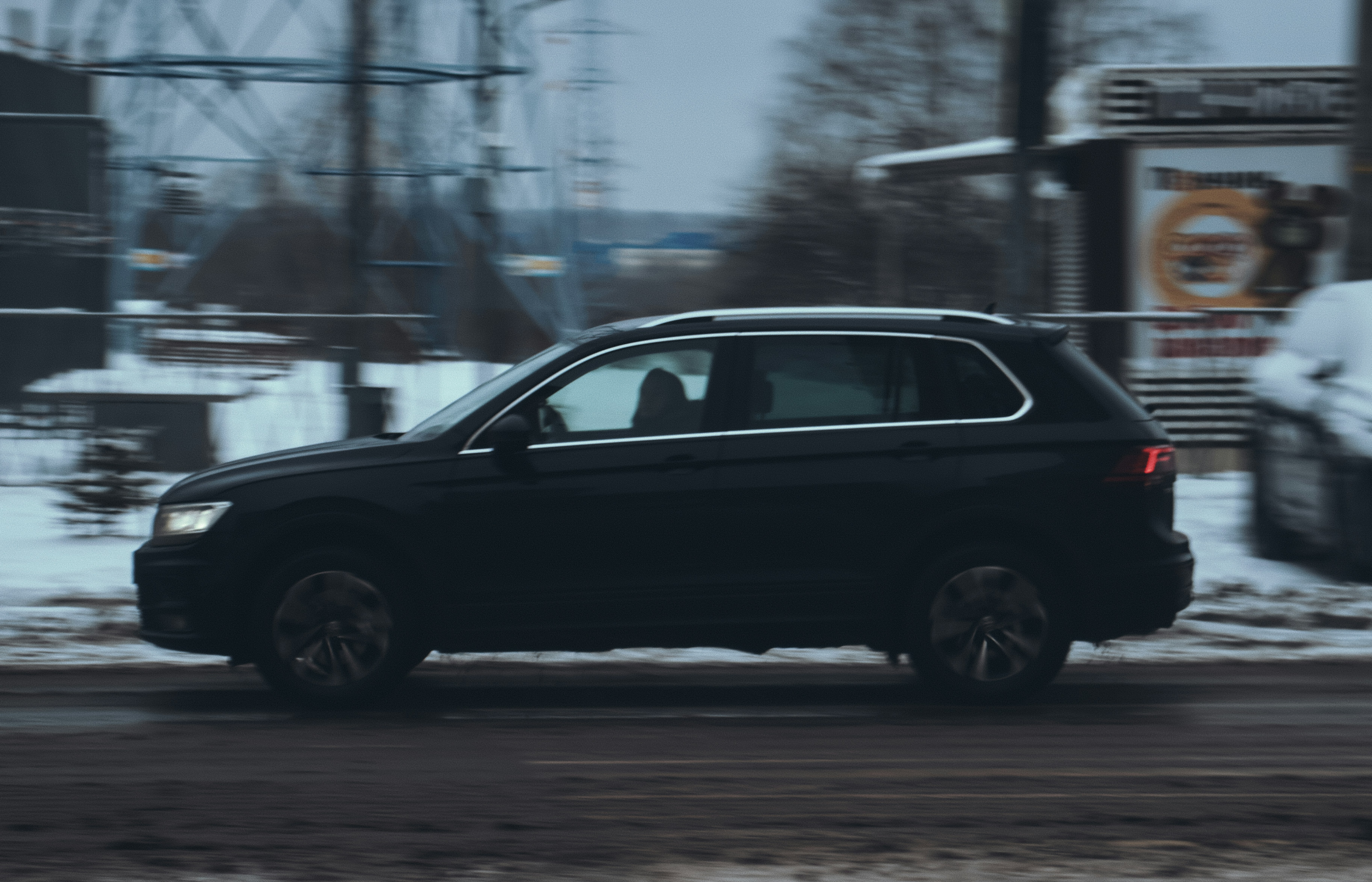 Midtown Midnight Run: A Black SUV in Motion Across a Snowy Street