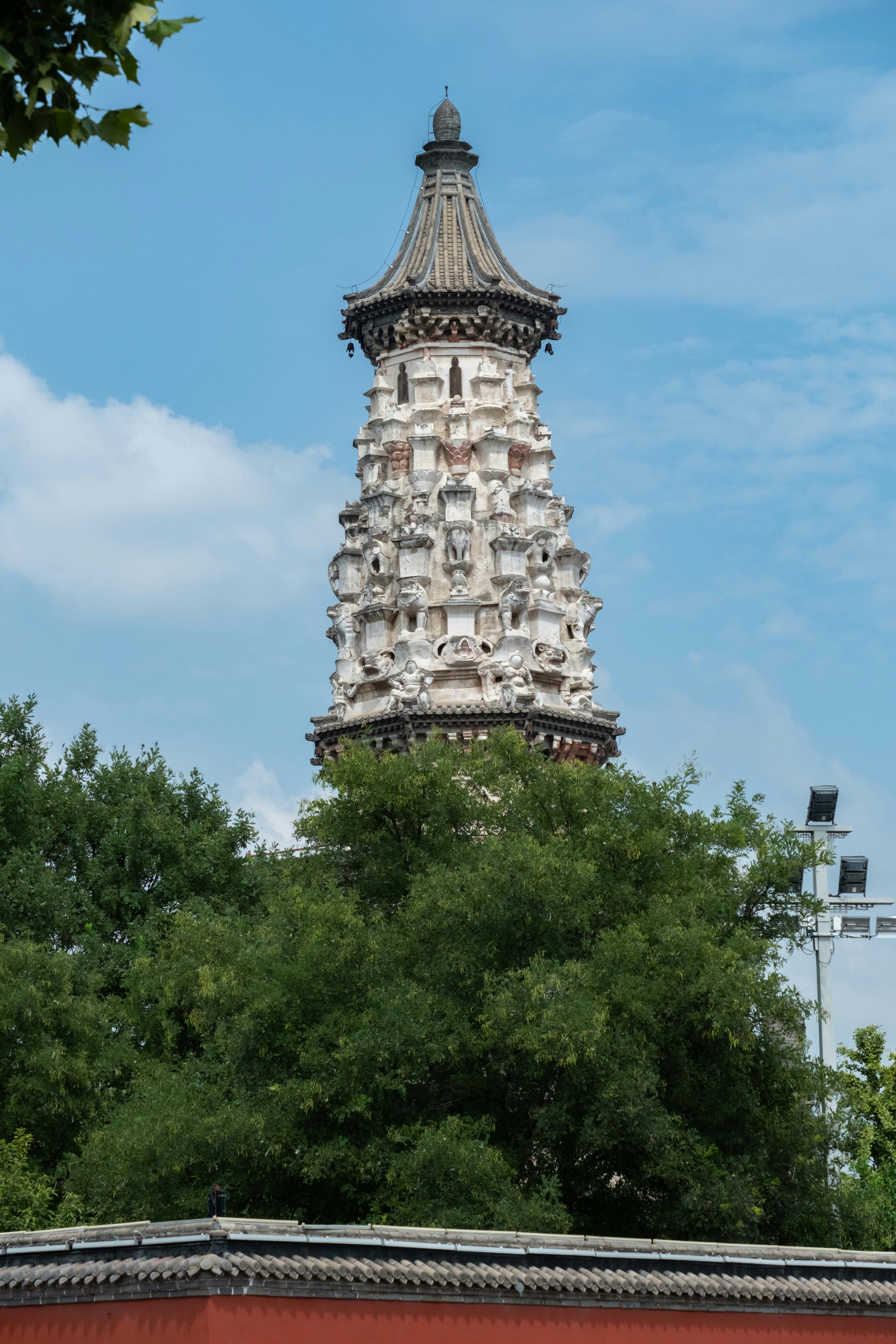 Stone Pagoda Rising Above Green Canopy Under a Clear Sky