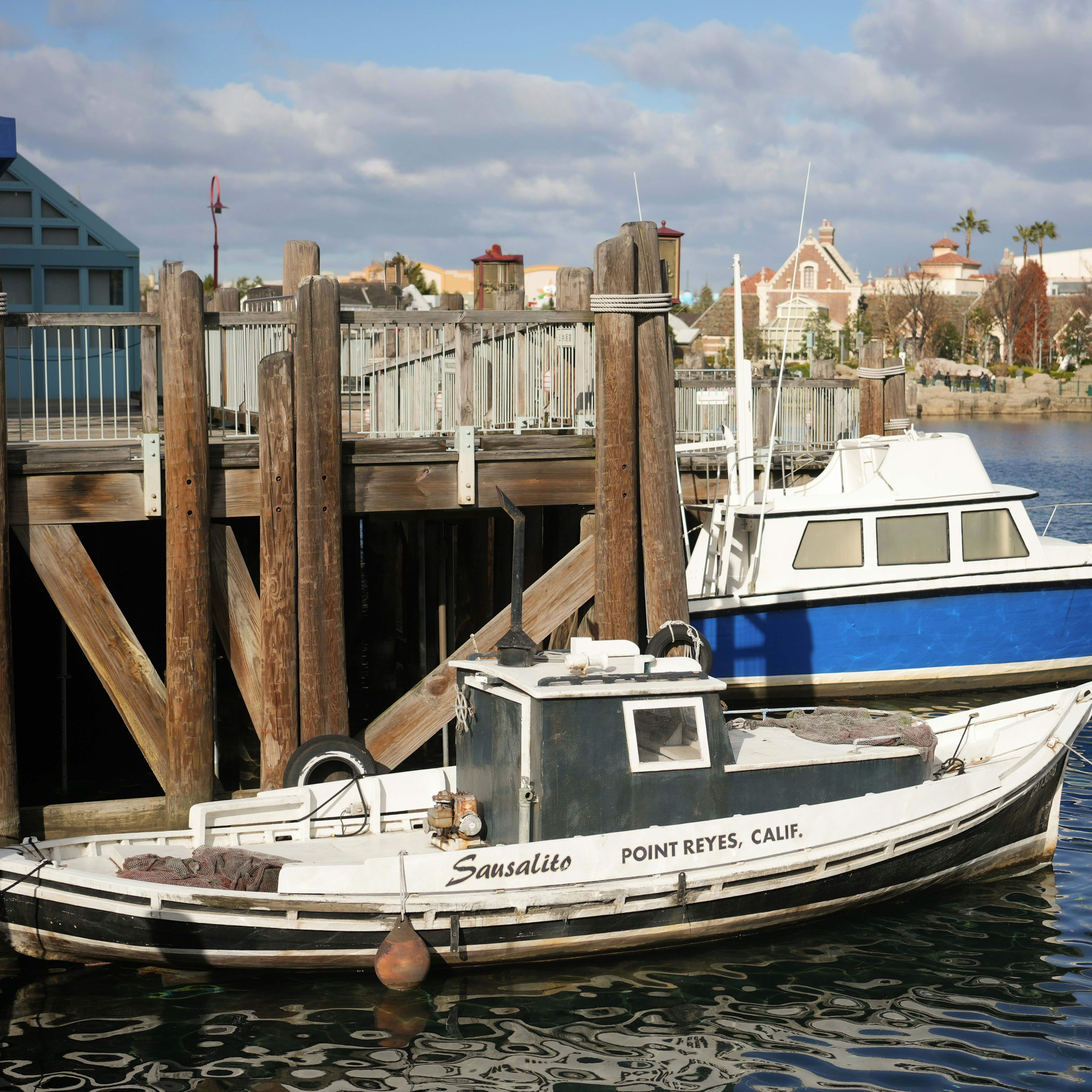 Sailing Clip: A Weathered Boat Tied to a Dock with Waterfront Pastel Village