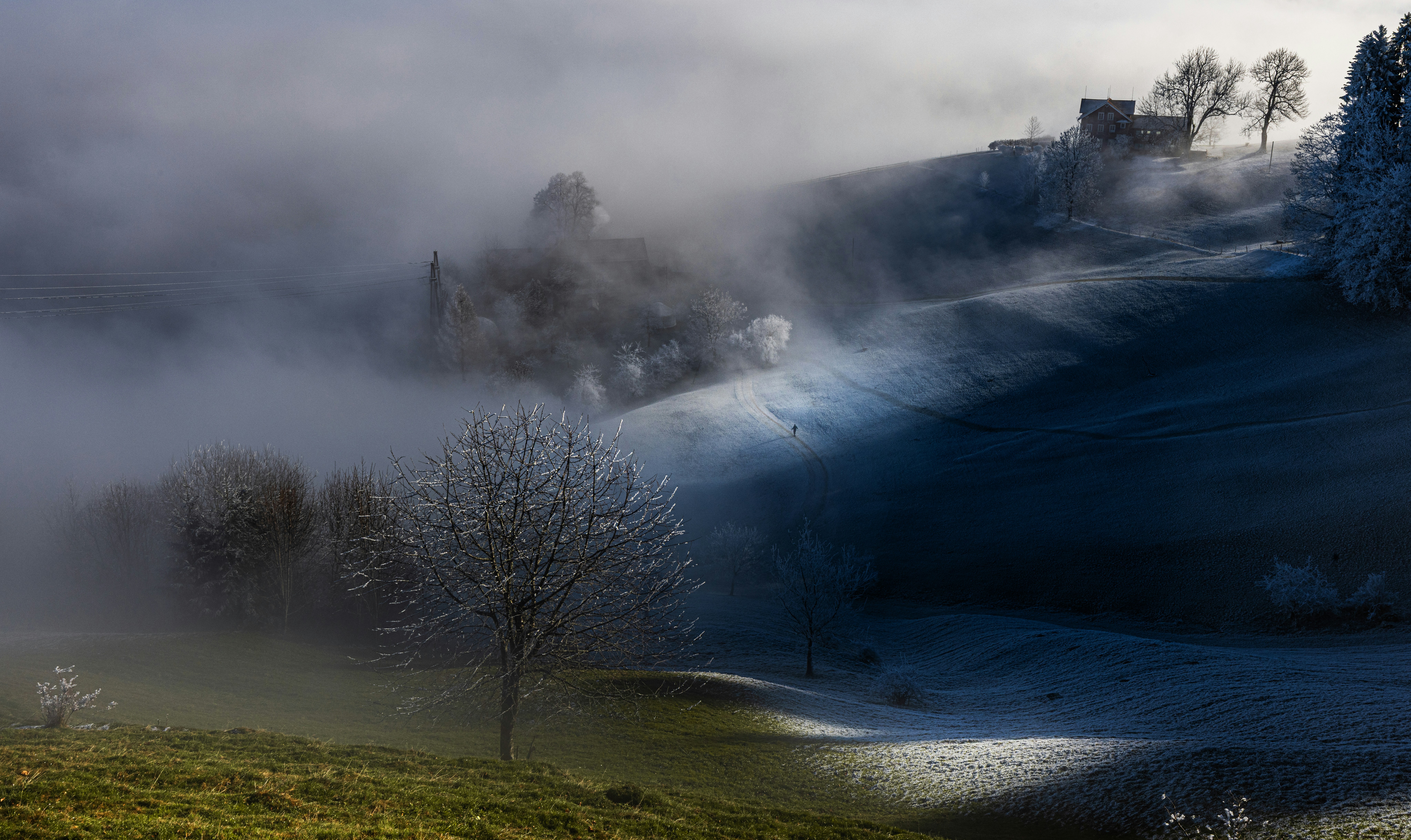 Mist on the Hill: A Snowlit Crest Emerges from Quiet Fog