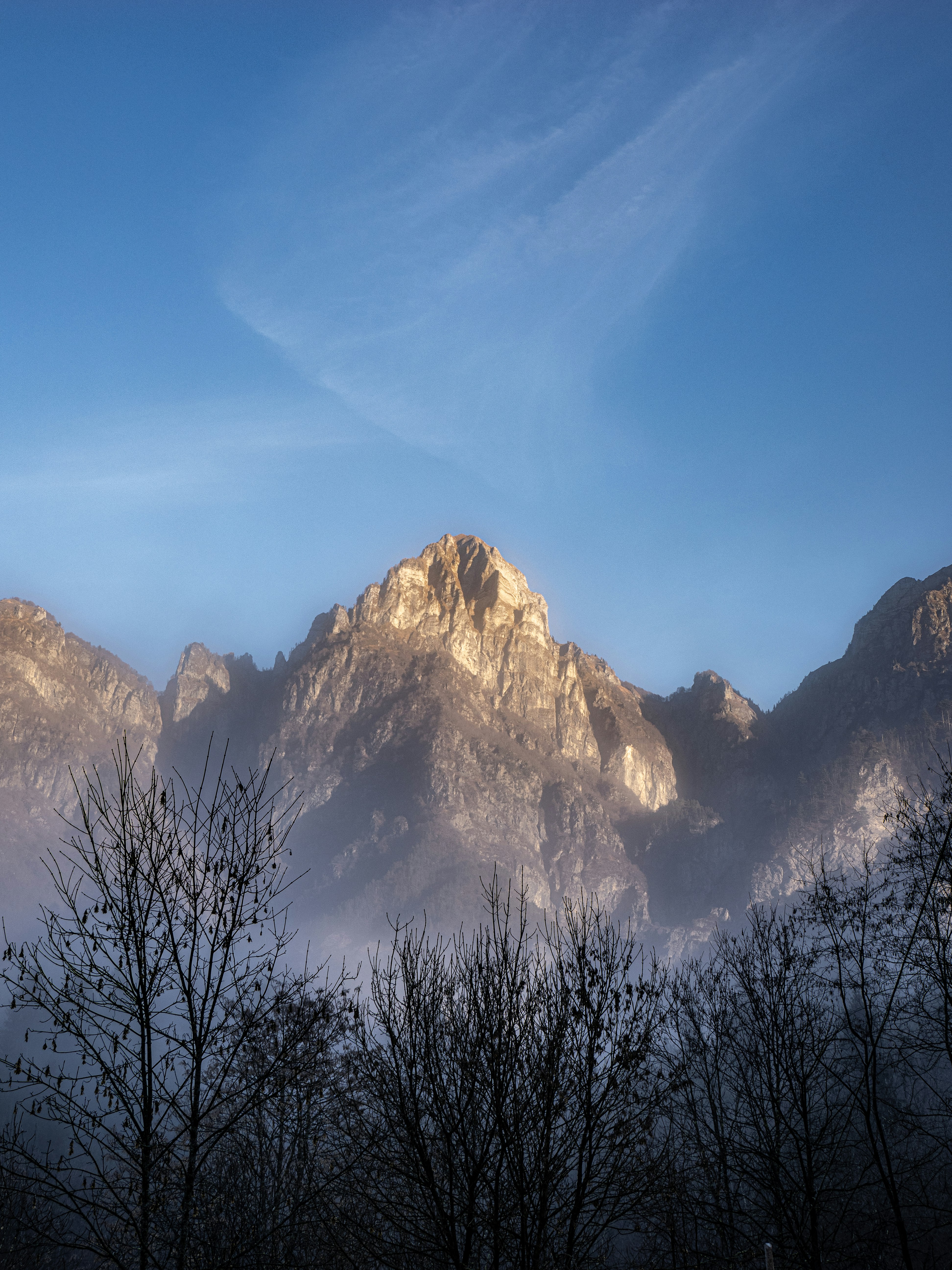 Sunlit summit peeking through morning mist