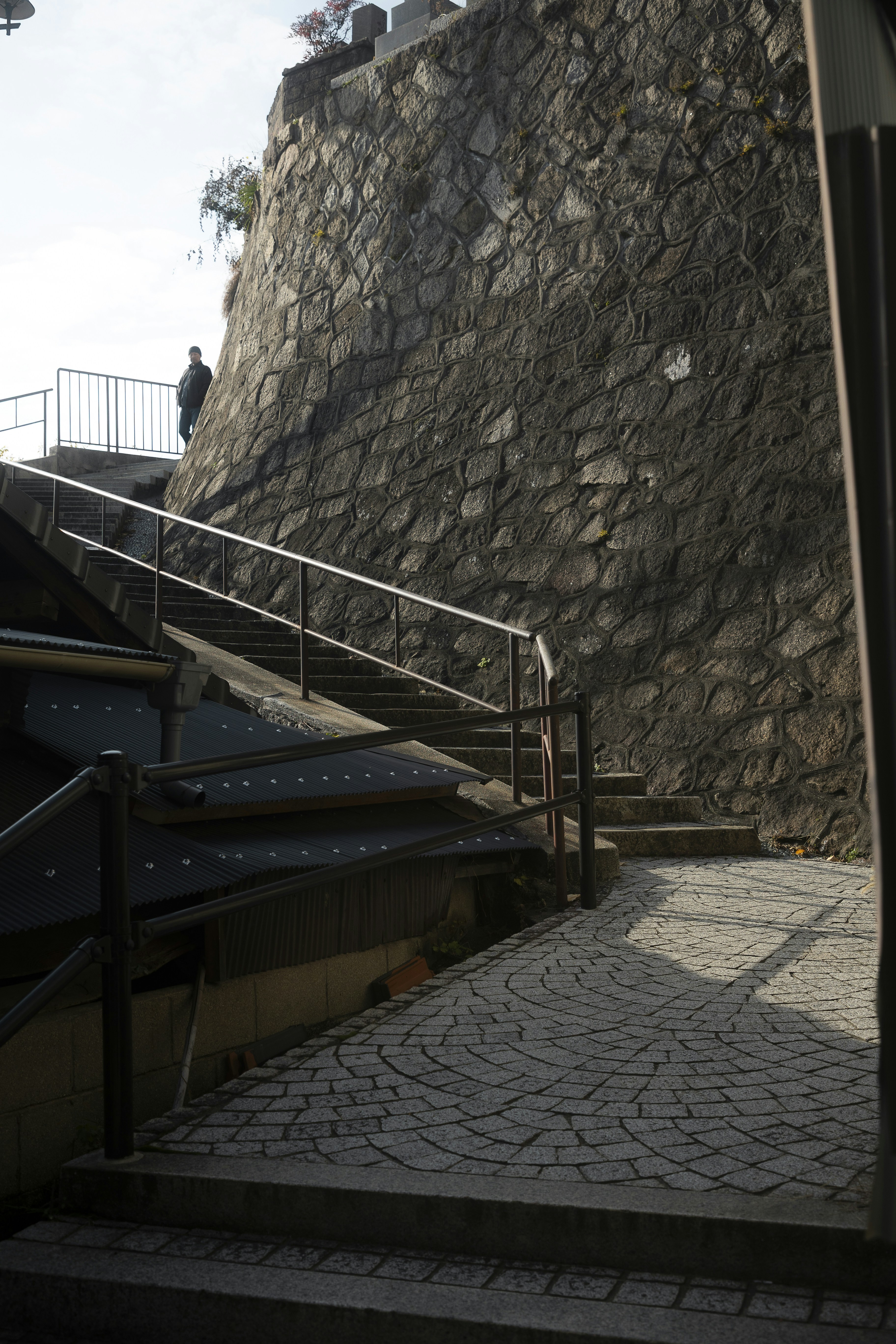 Stone Cliff Staircase: A Quiet Figure Beside the Wall