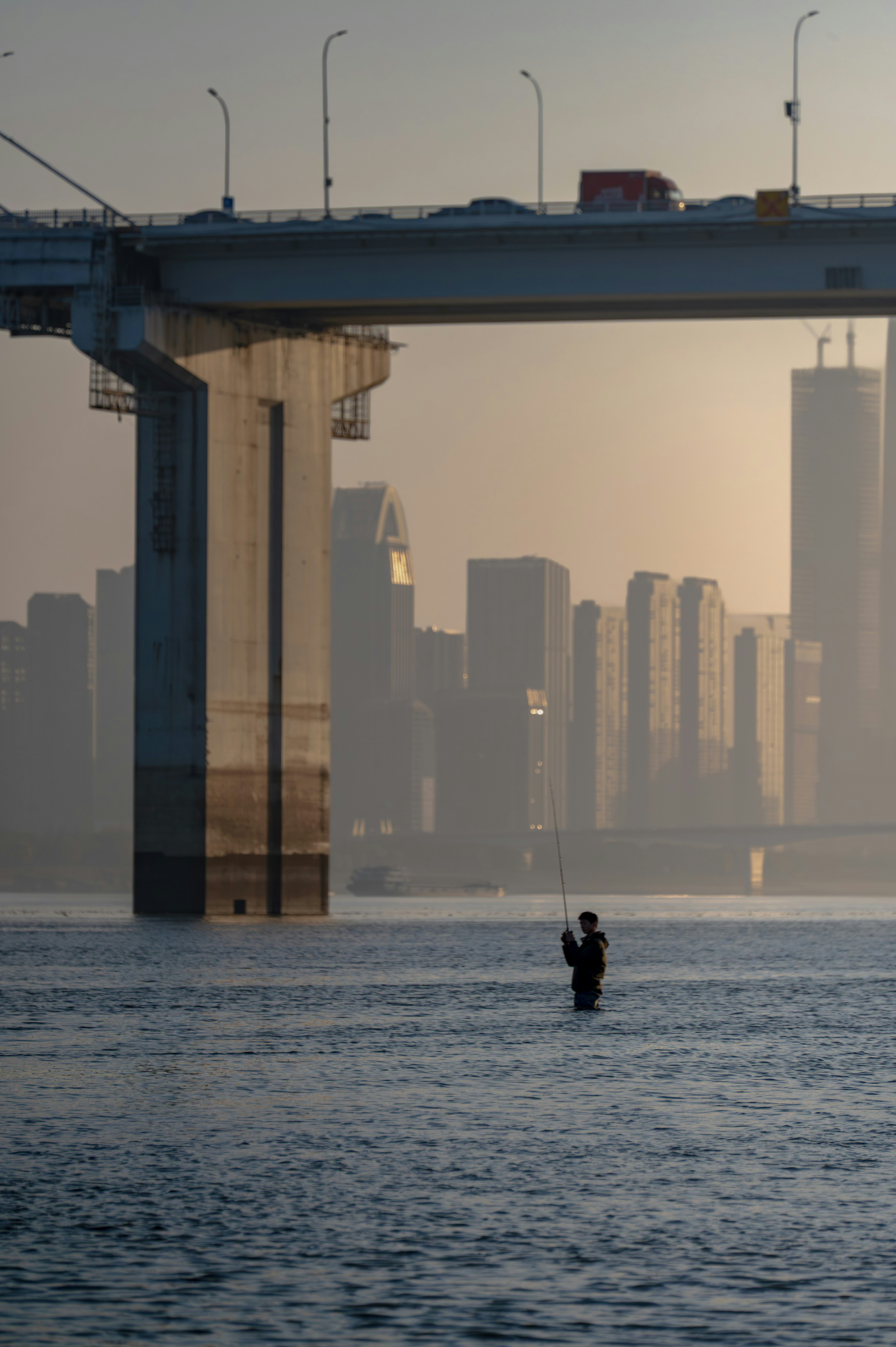 Bridge Over Quiet Tides: A Fisherman in the Urban Fog