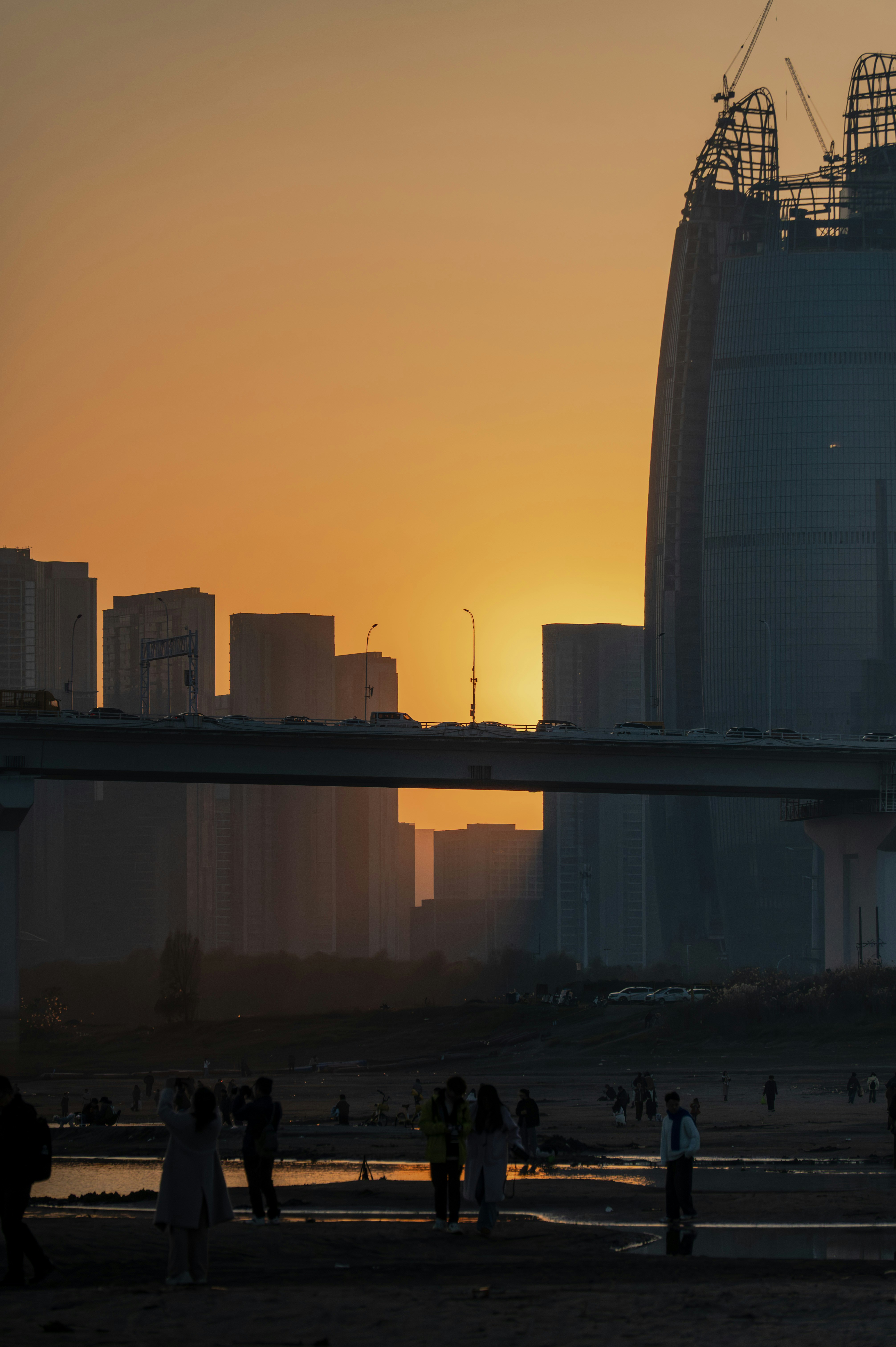 Sunset Over the City: A Silhouette of Towers and a Quiet Beach