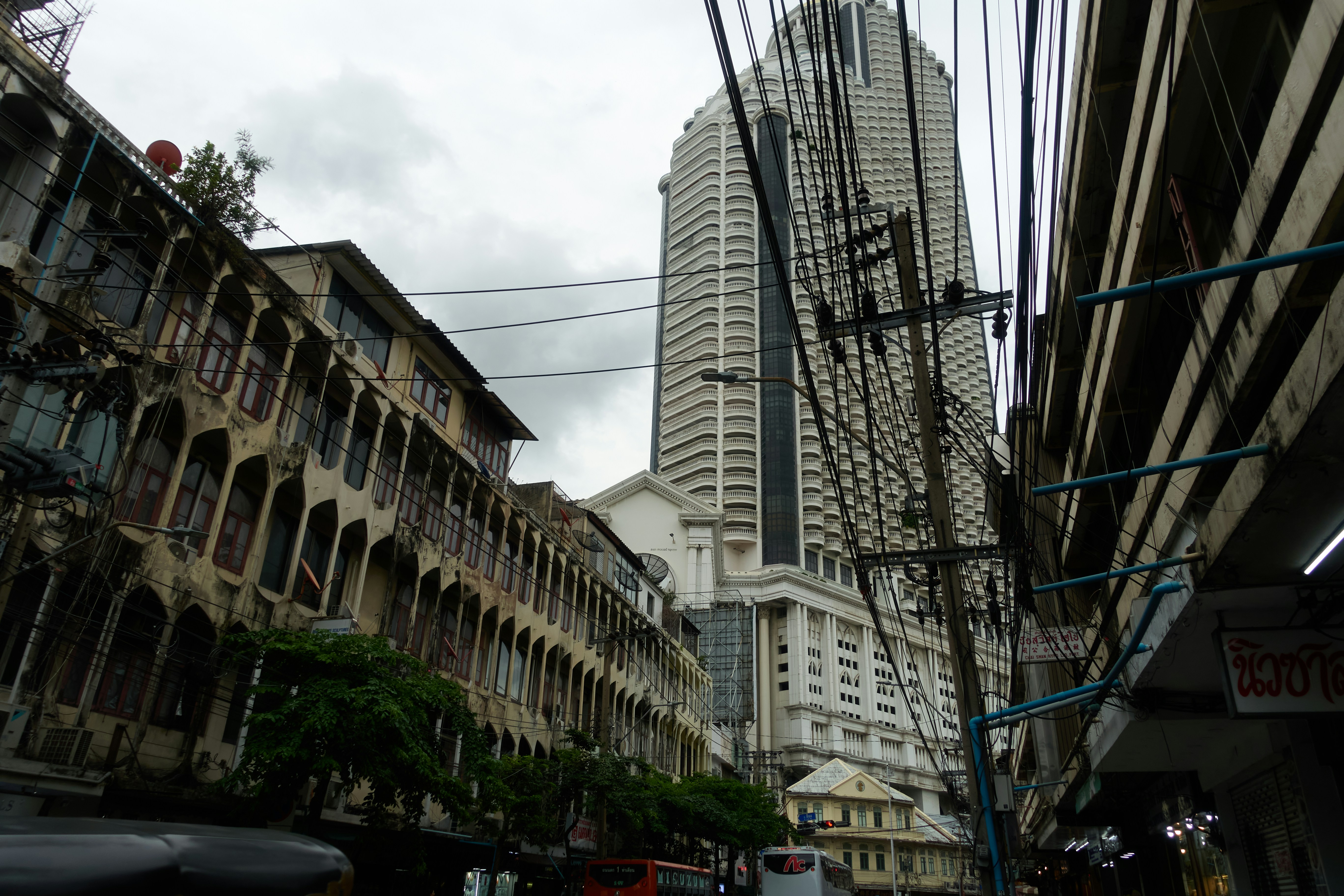 Urban Confluence: Skyscraper Rising Above Historic Shophouses