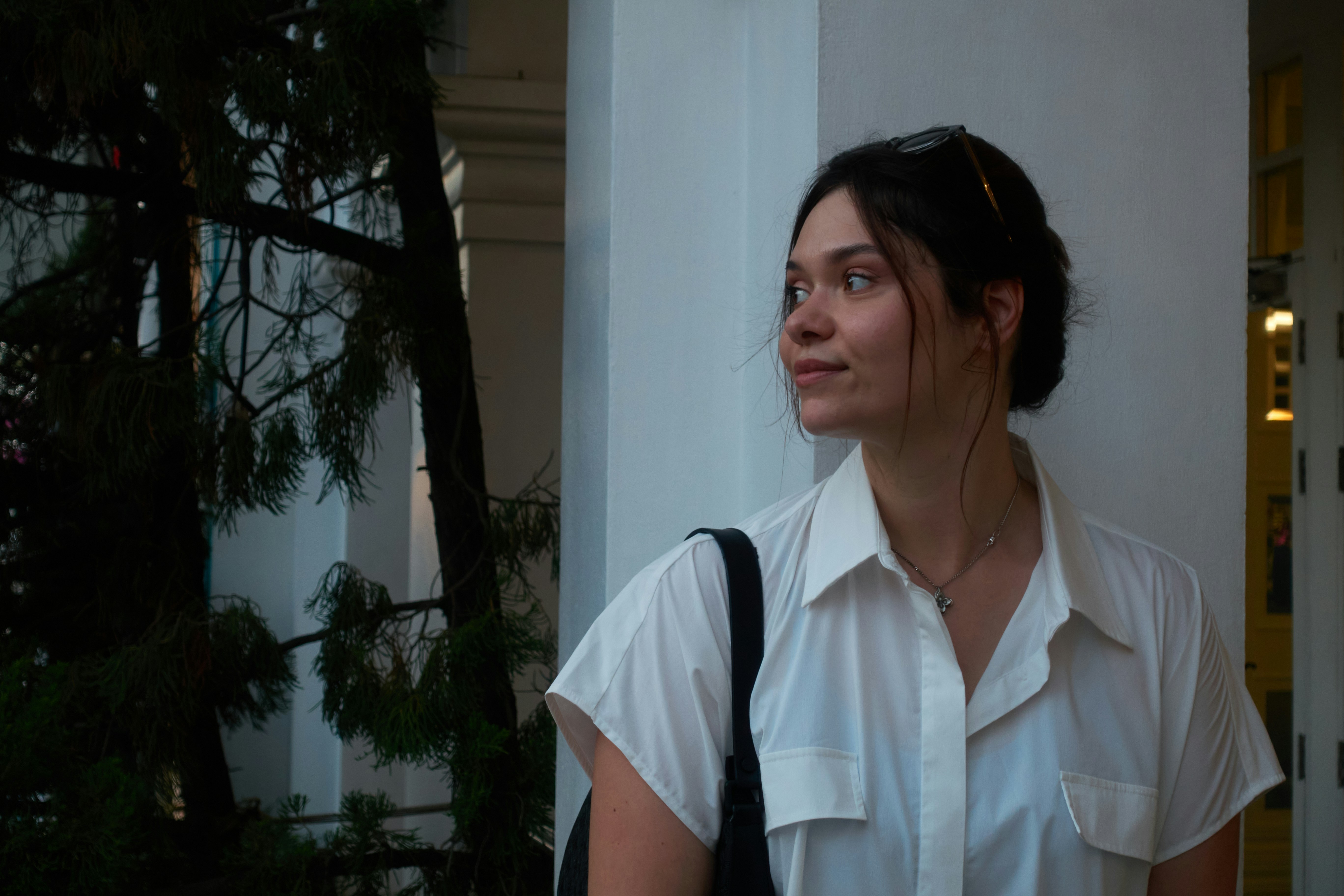 Portrait in Soft Light: A Woman in White at a Courtyard Edge