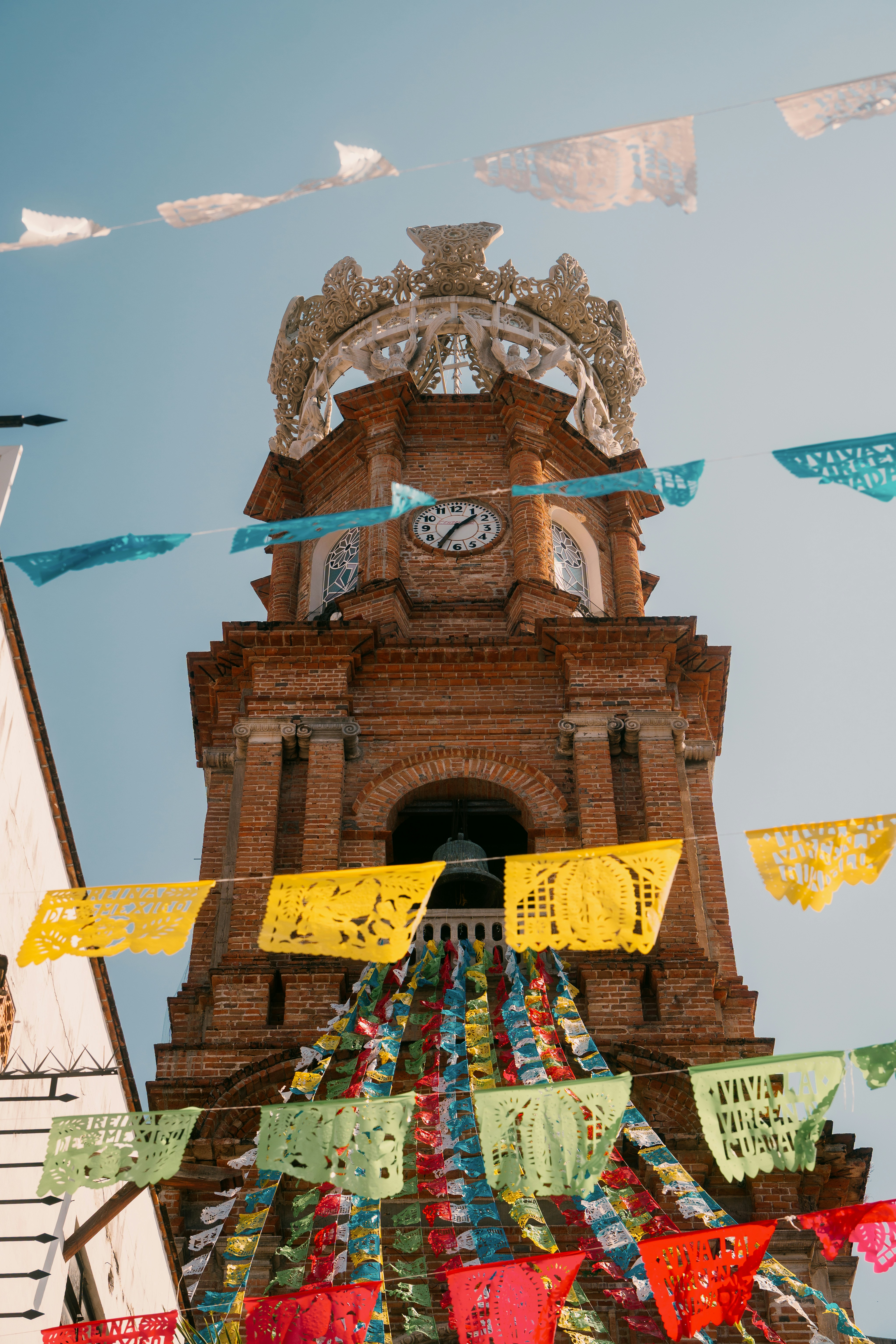 Brick Clock Tower Beneath Colorful Prayer Flags