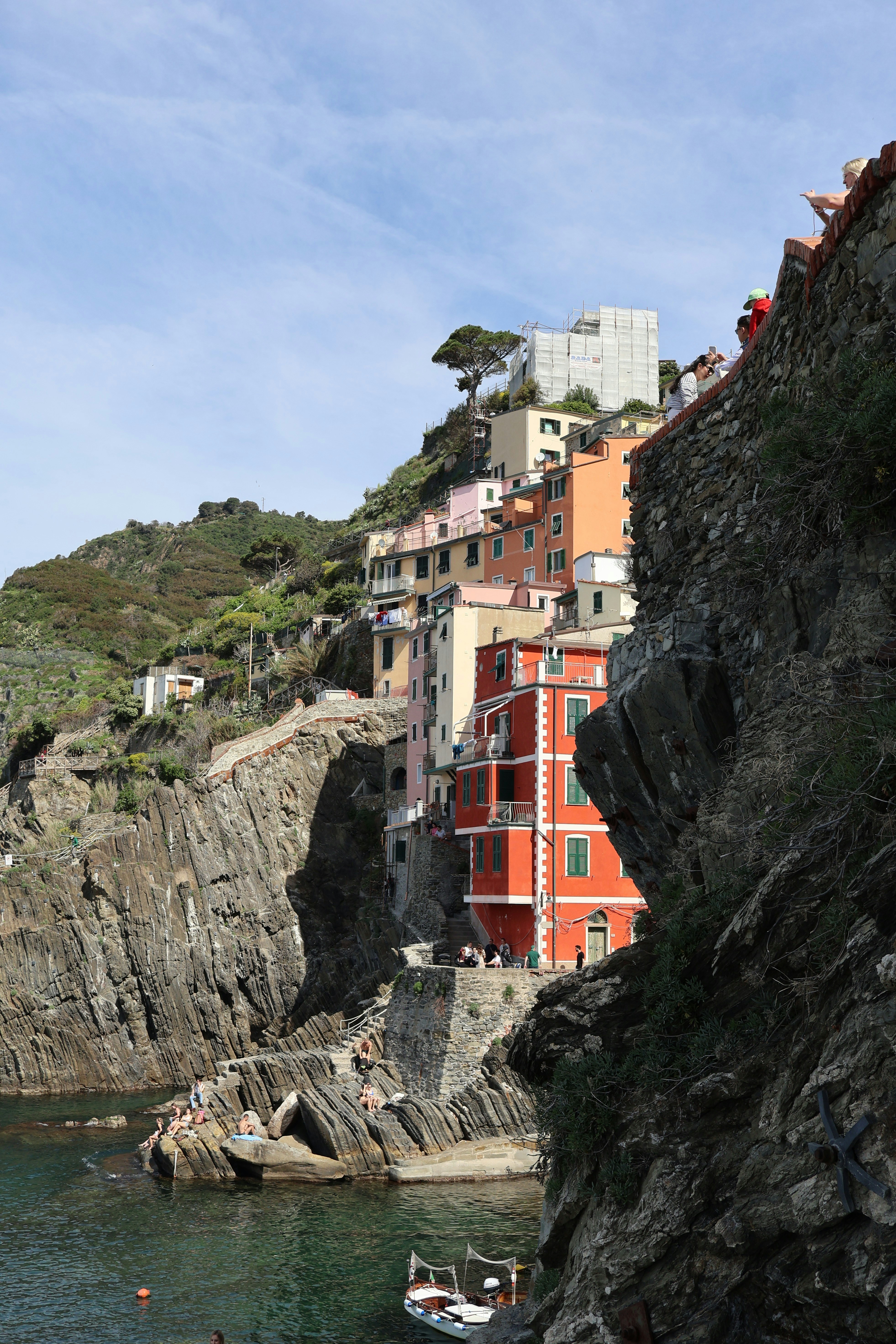 Colorful hillside village clinging to basalt cliffs above a quiet harbor