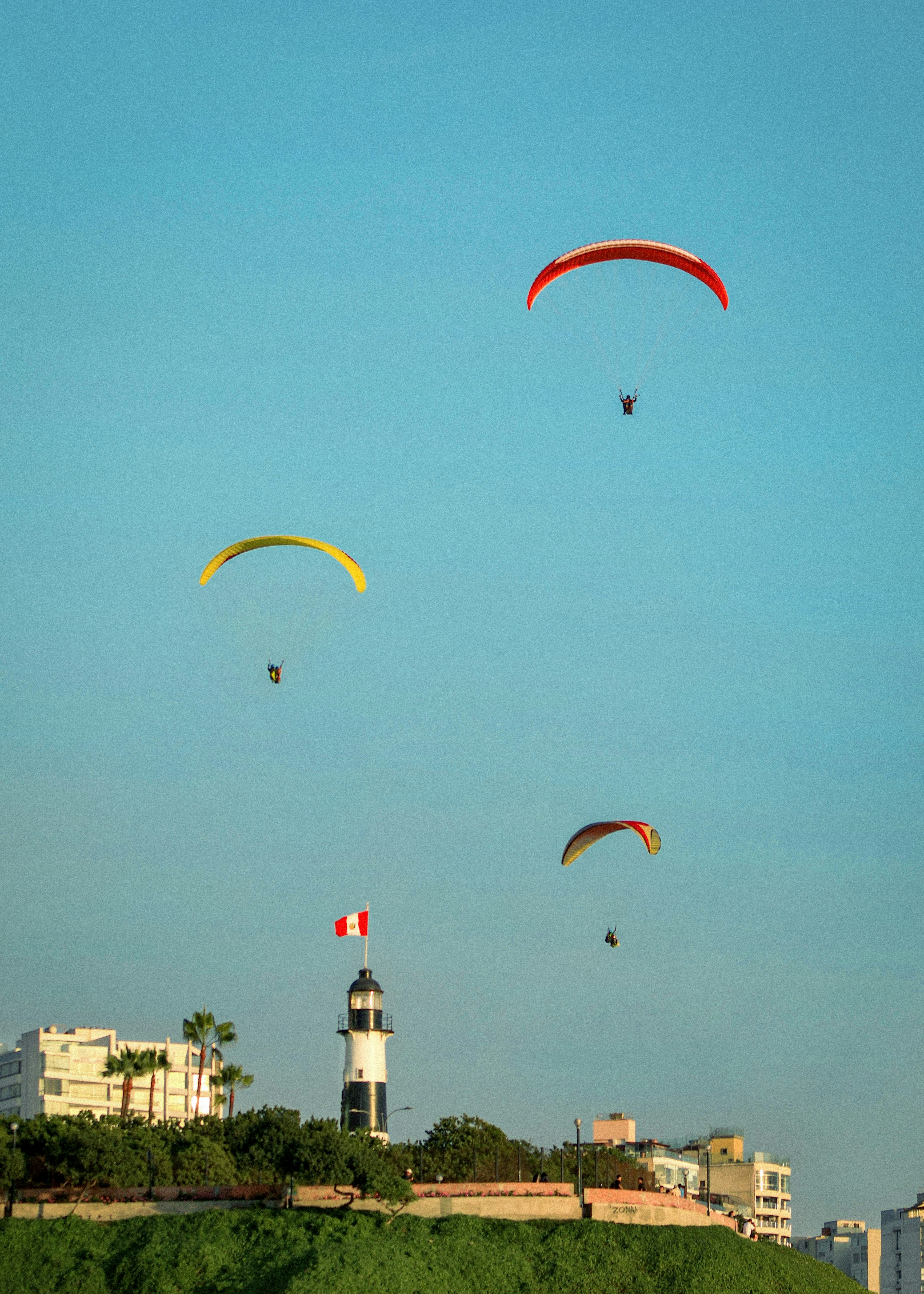 Paragliders over a coastal town at blue hour