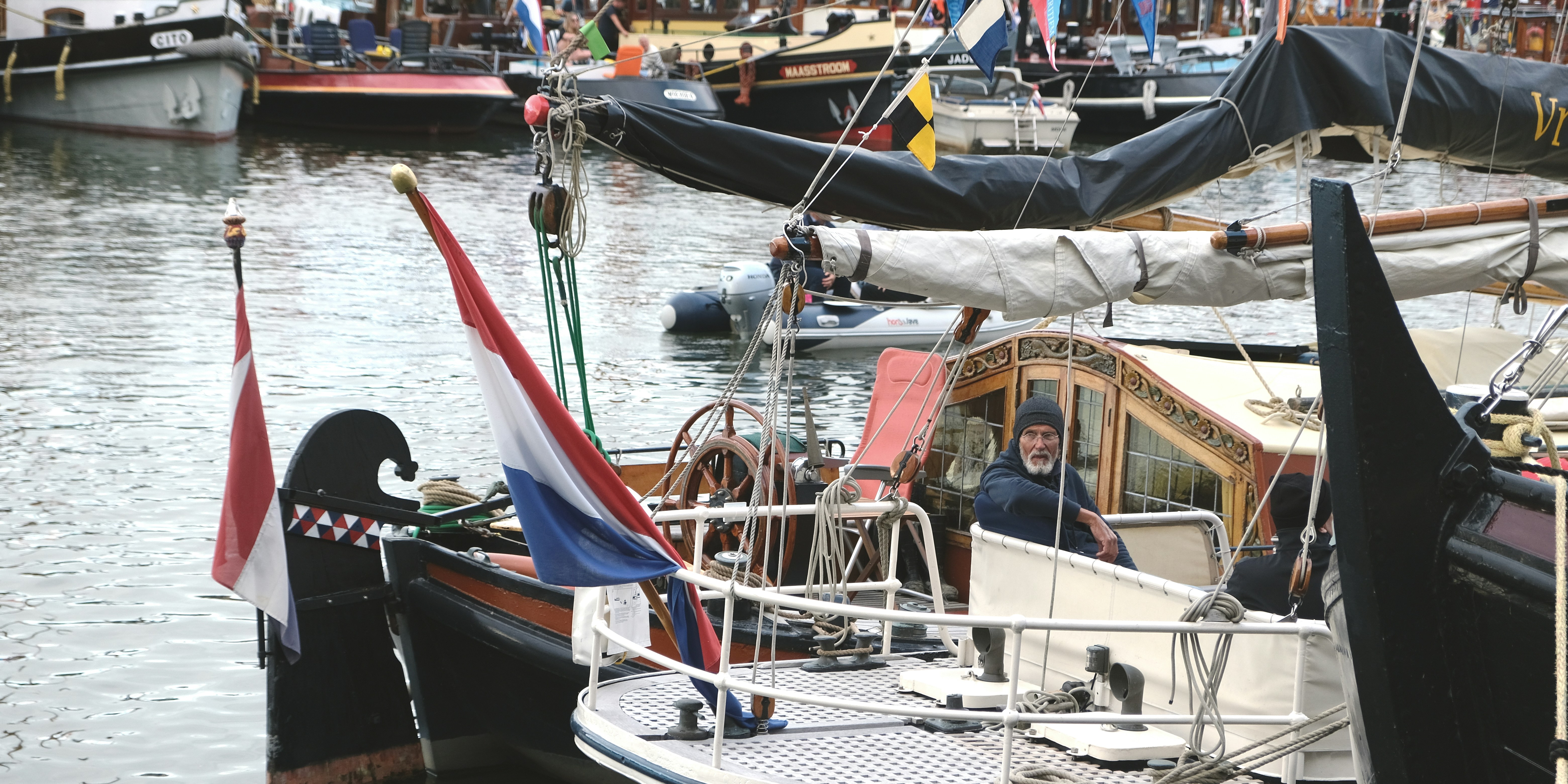 Harbor Canvas: Boats, Flags, and a Quiet Sailor