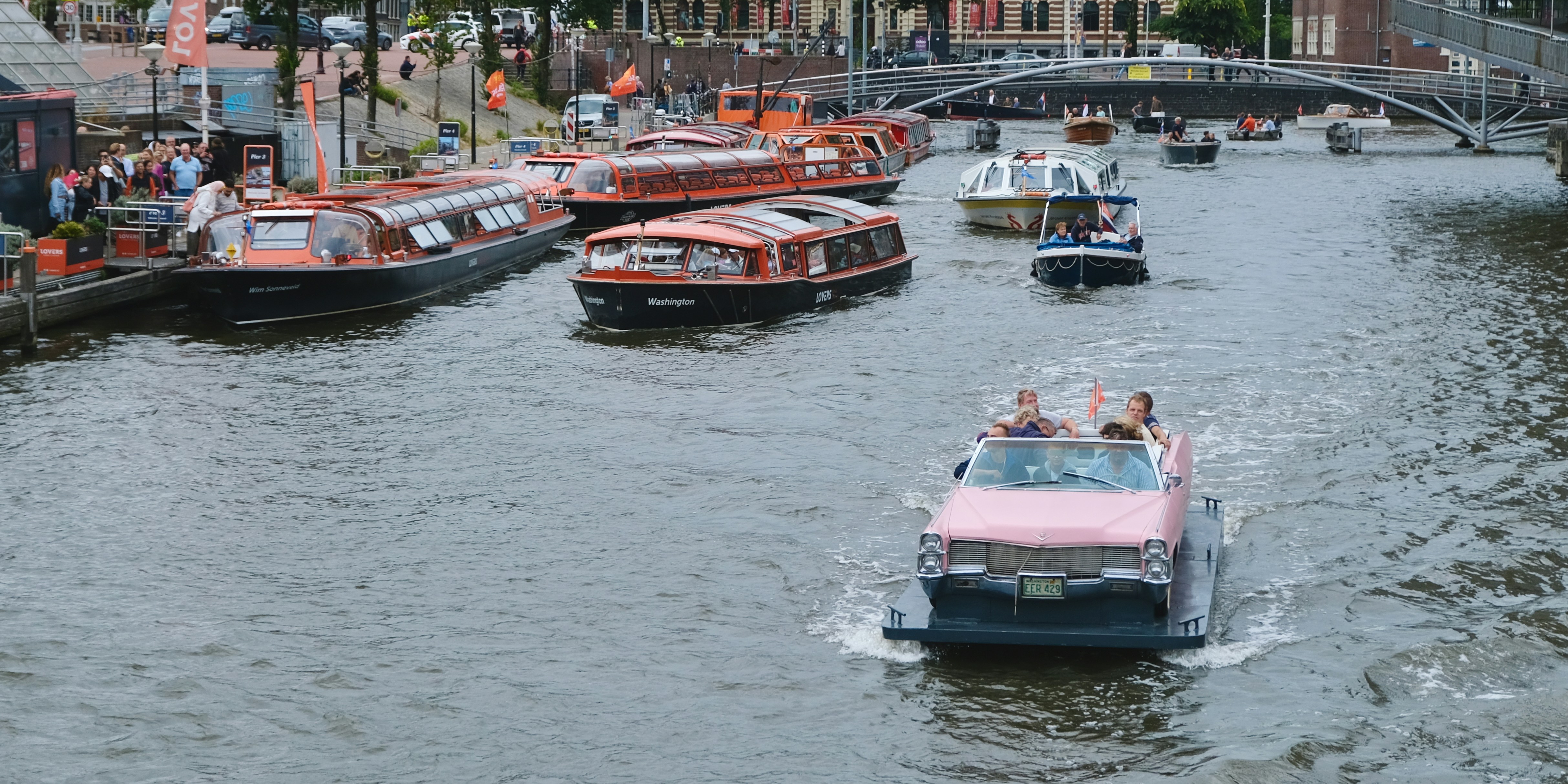 Pink Convertible Cruisers: Boats Slip Through a City Canal