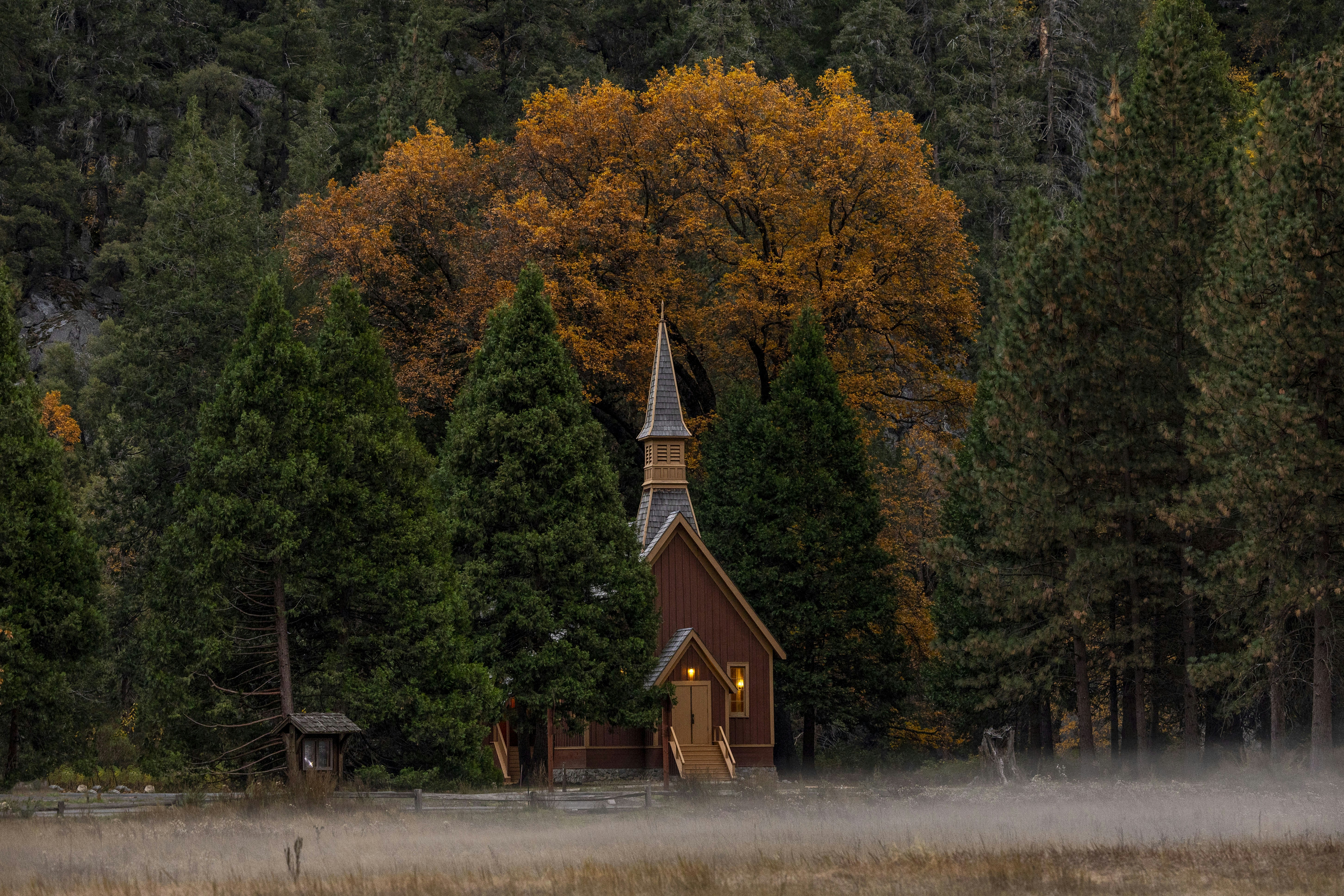 Autumn chapel in a foggy meadow