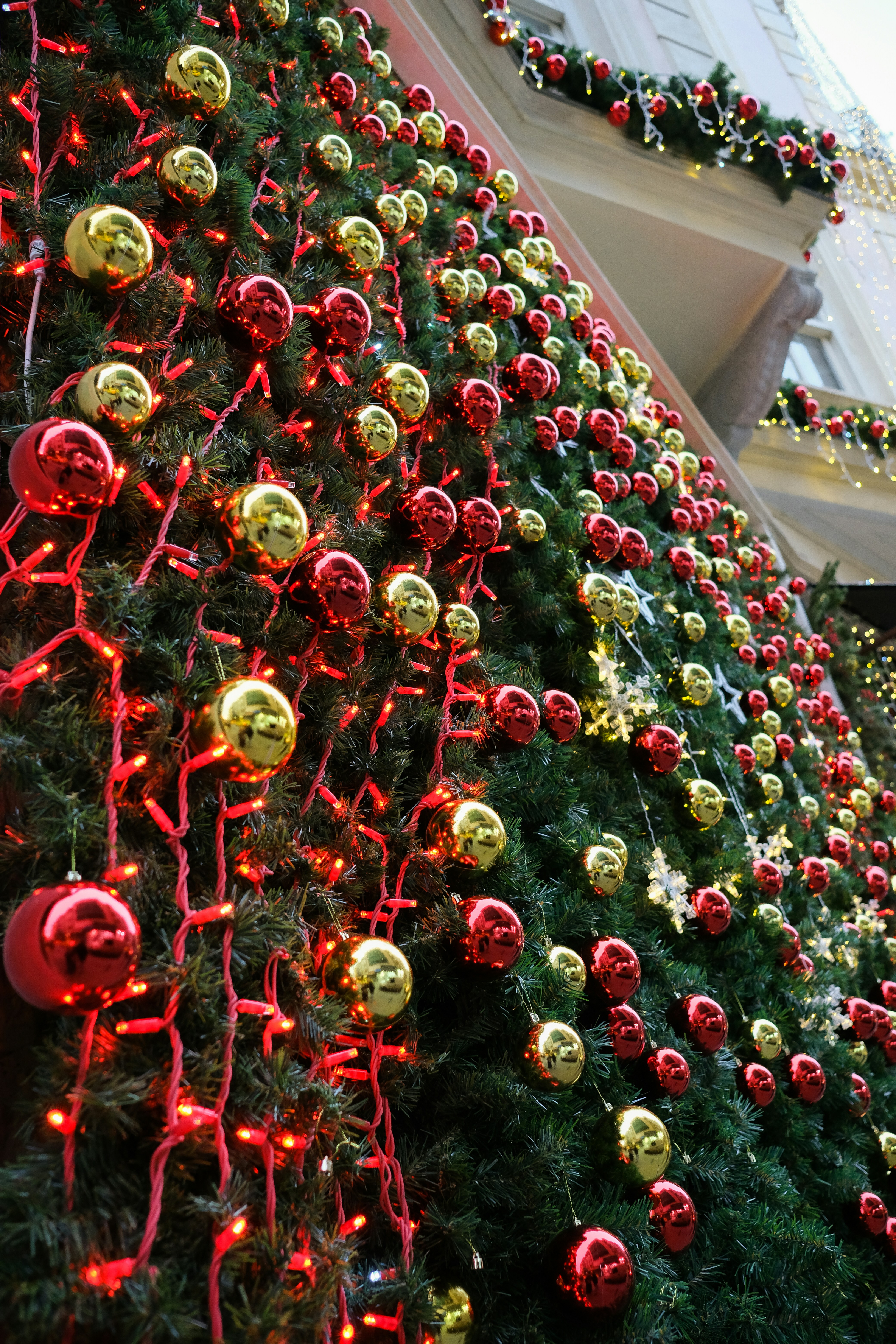 Cascade of Red and Gold: A Christmas Tree Wall Adorned with Orbs