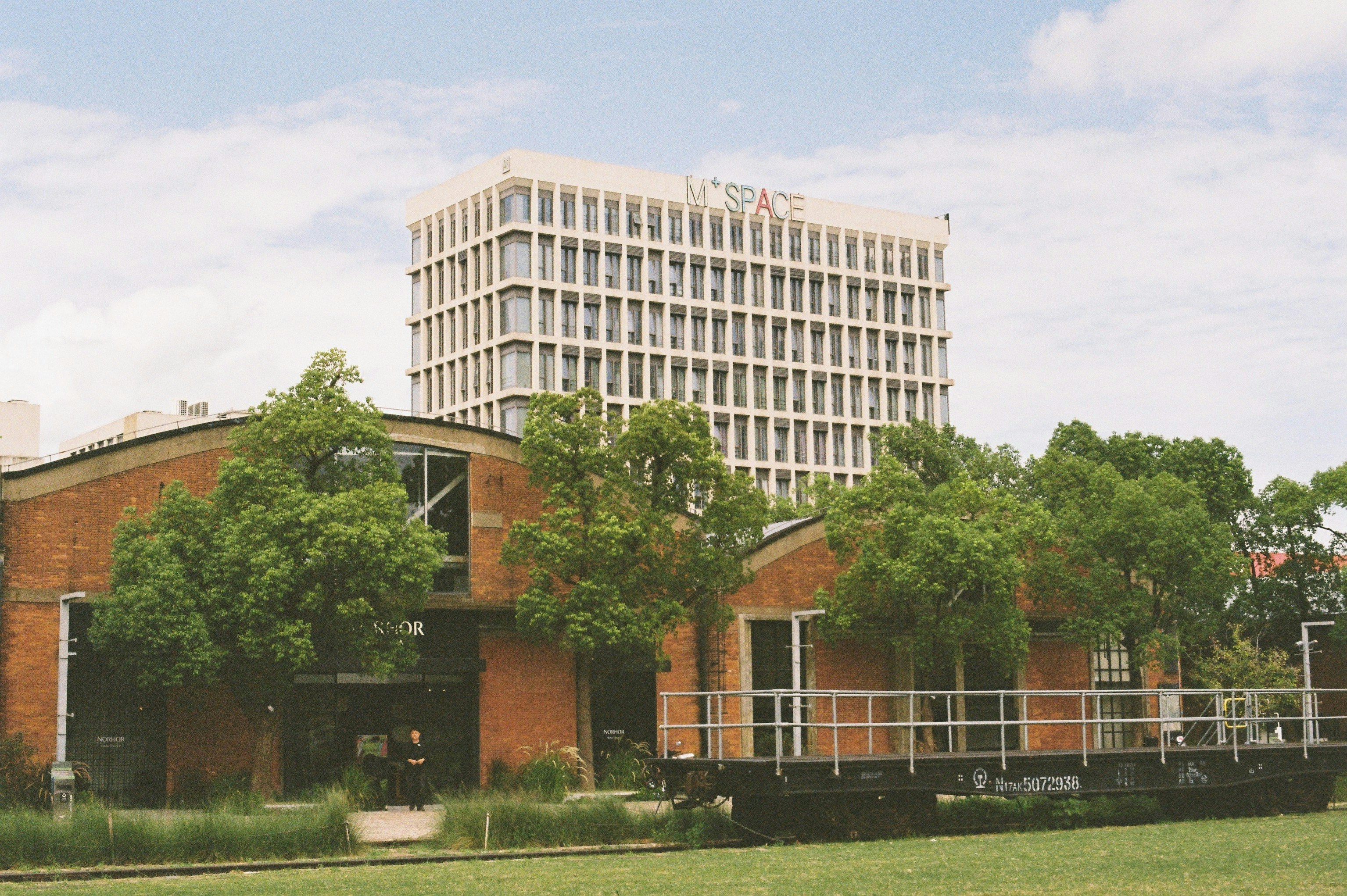 Brick Terrace by the River: Urban Campus Meets Green Park