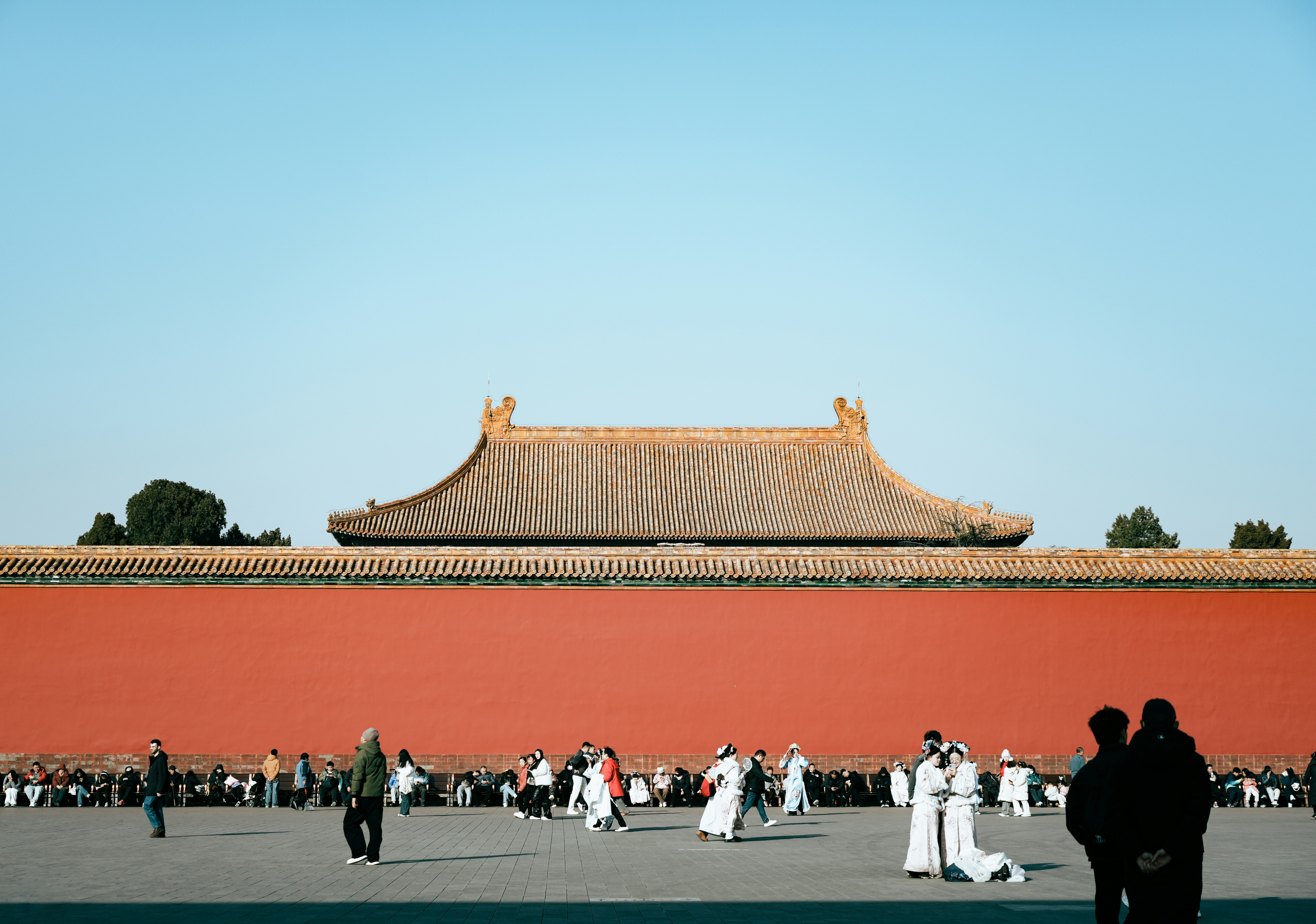 Ceremonial Wall and Courtyard: Visitors Gather Before a Historic Roofline