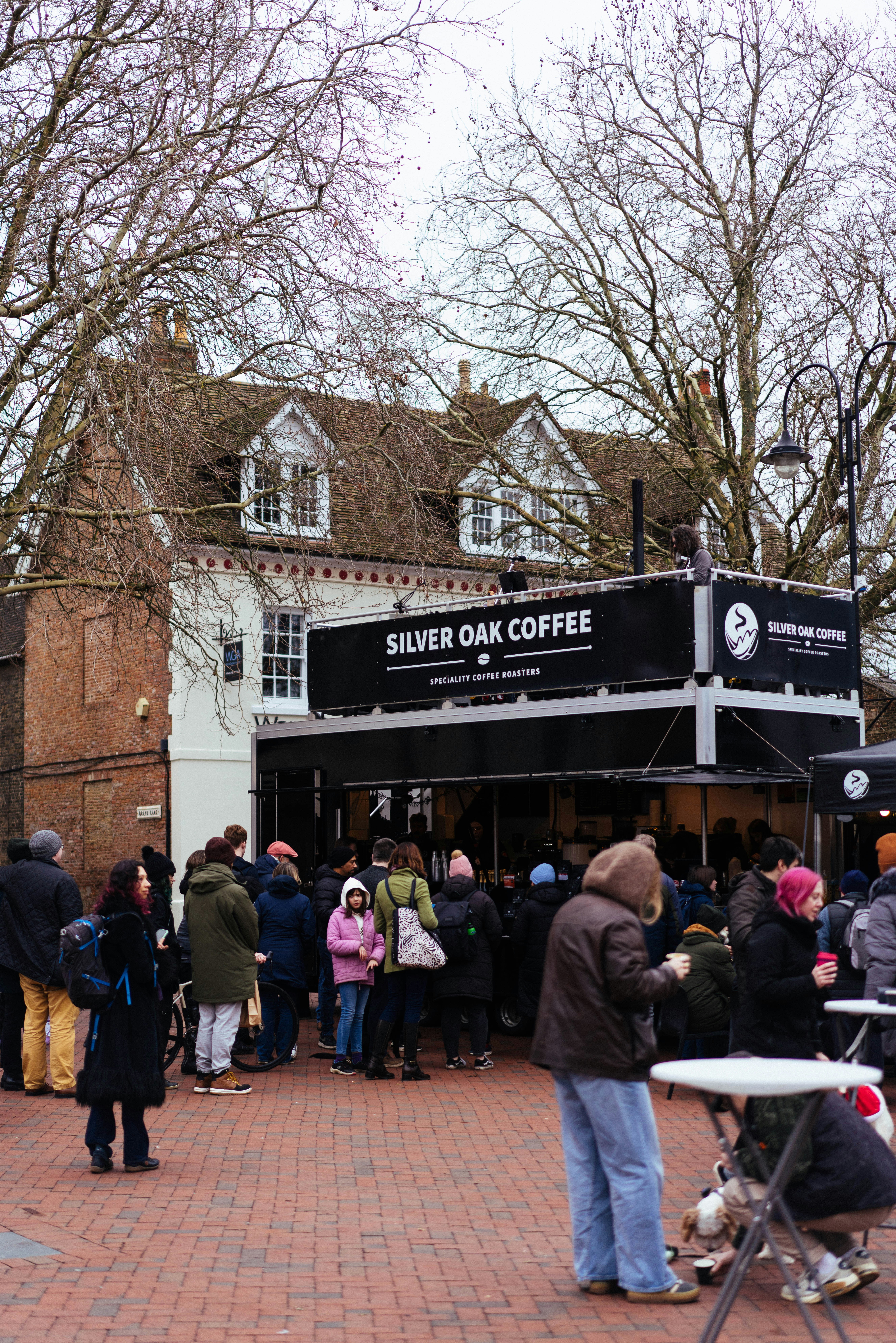 Crowd at Silver Oak Coffee Stand Framing a Busy Urban Square