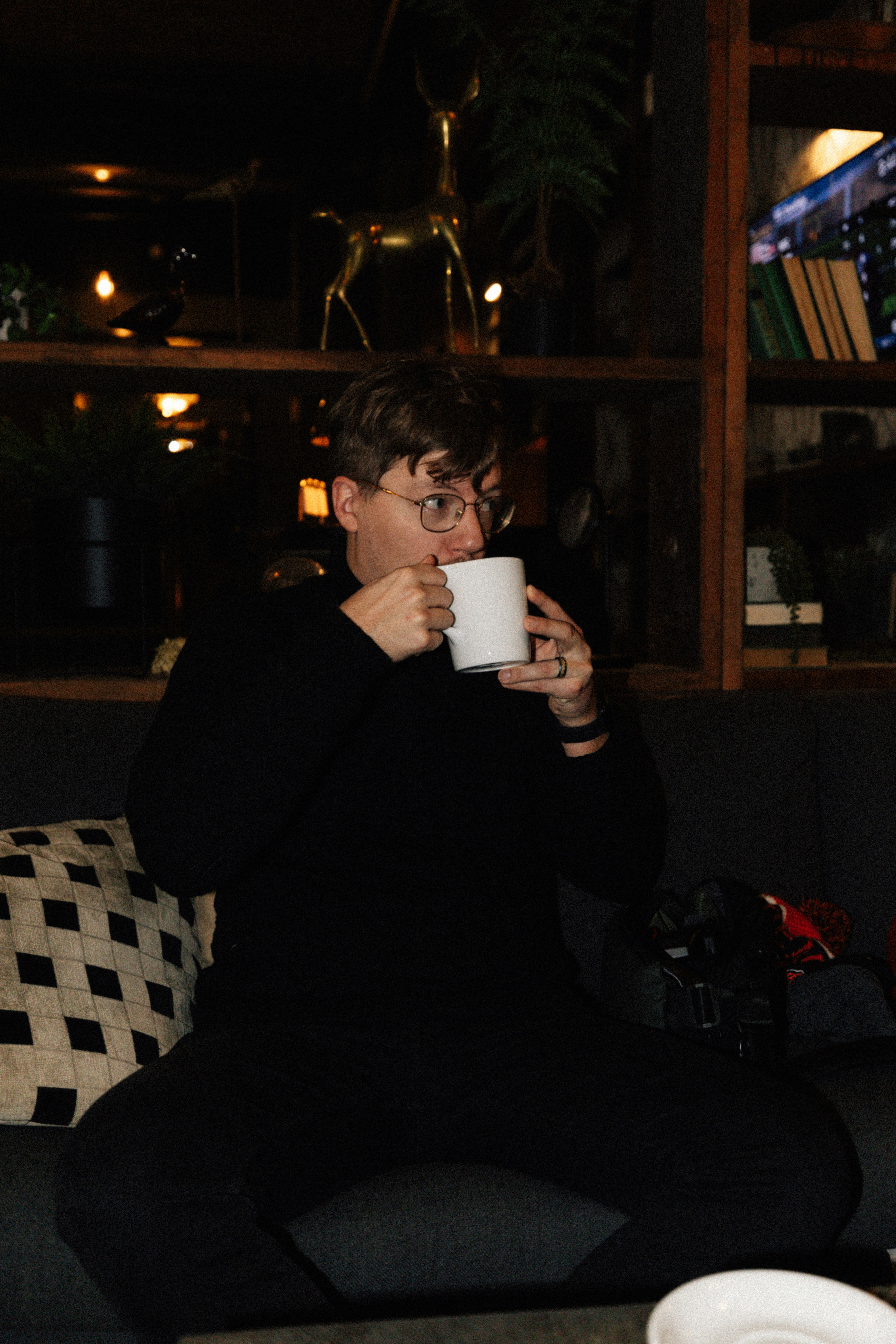 Quiet mug of warmth: a candid evening in the bookshelf glow