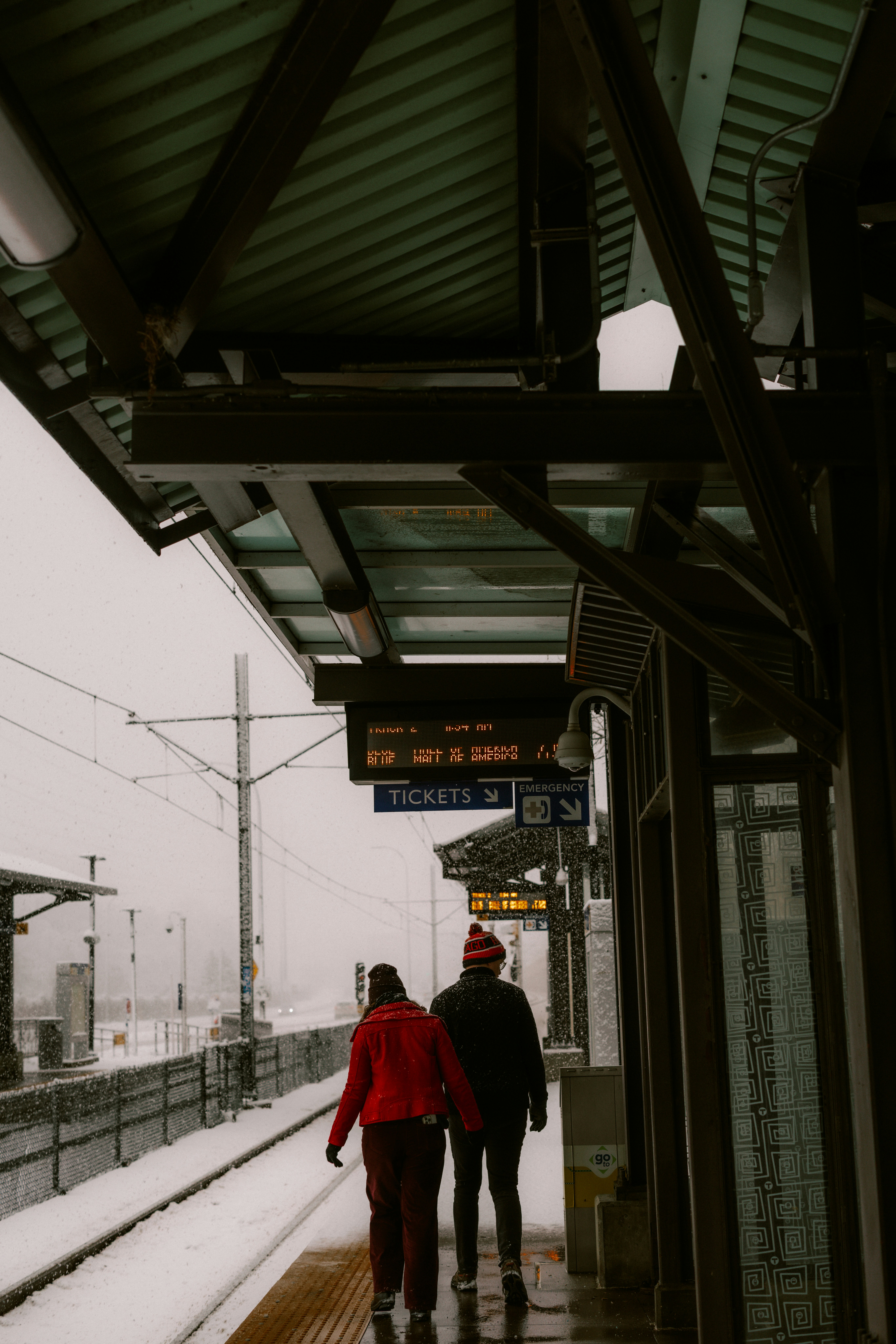 Snowy Platform Bond: Red Coat and Black Jacket Boldly Step Home