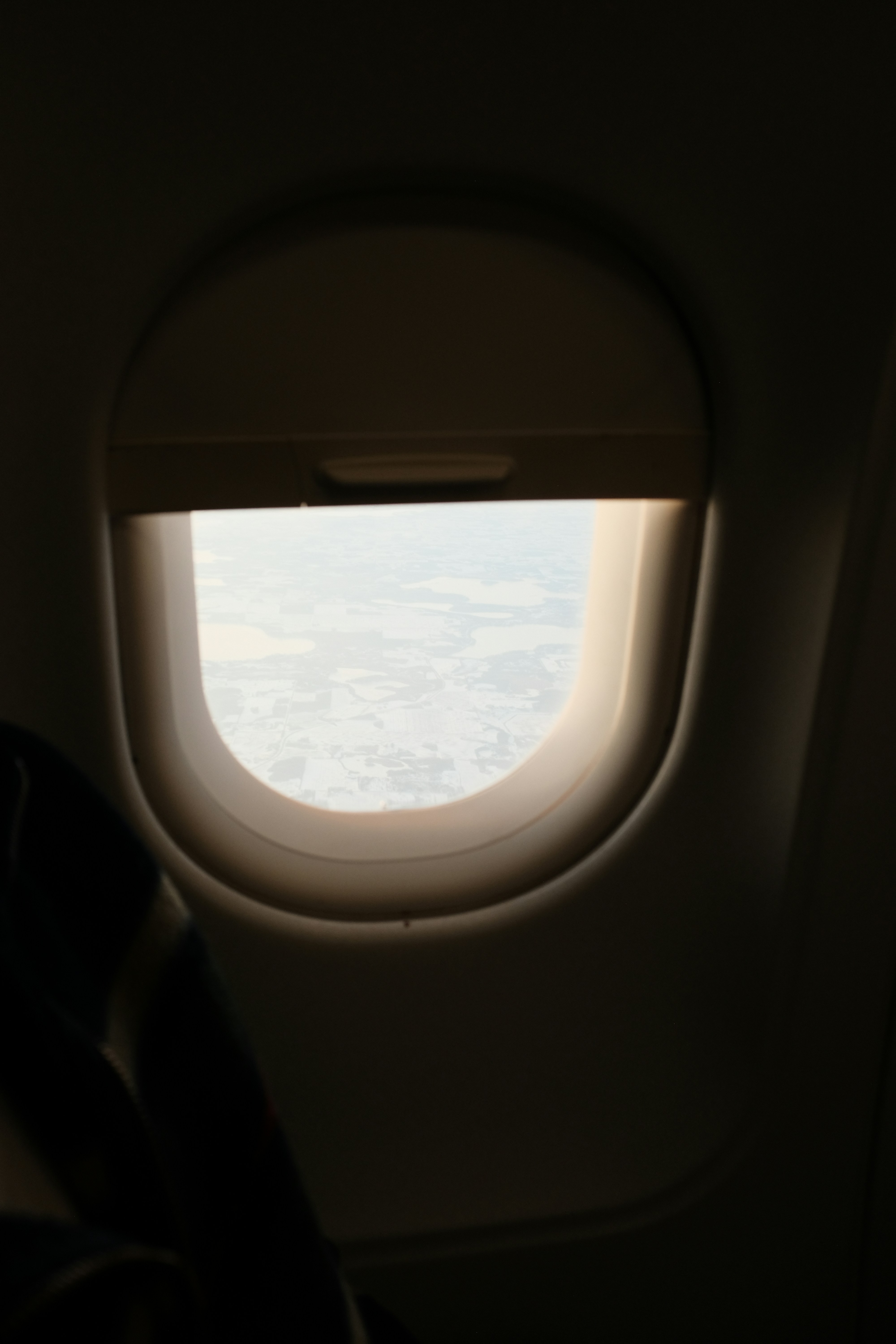 Window View: Snowy Quilt Beneath an Airplane Window
