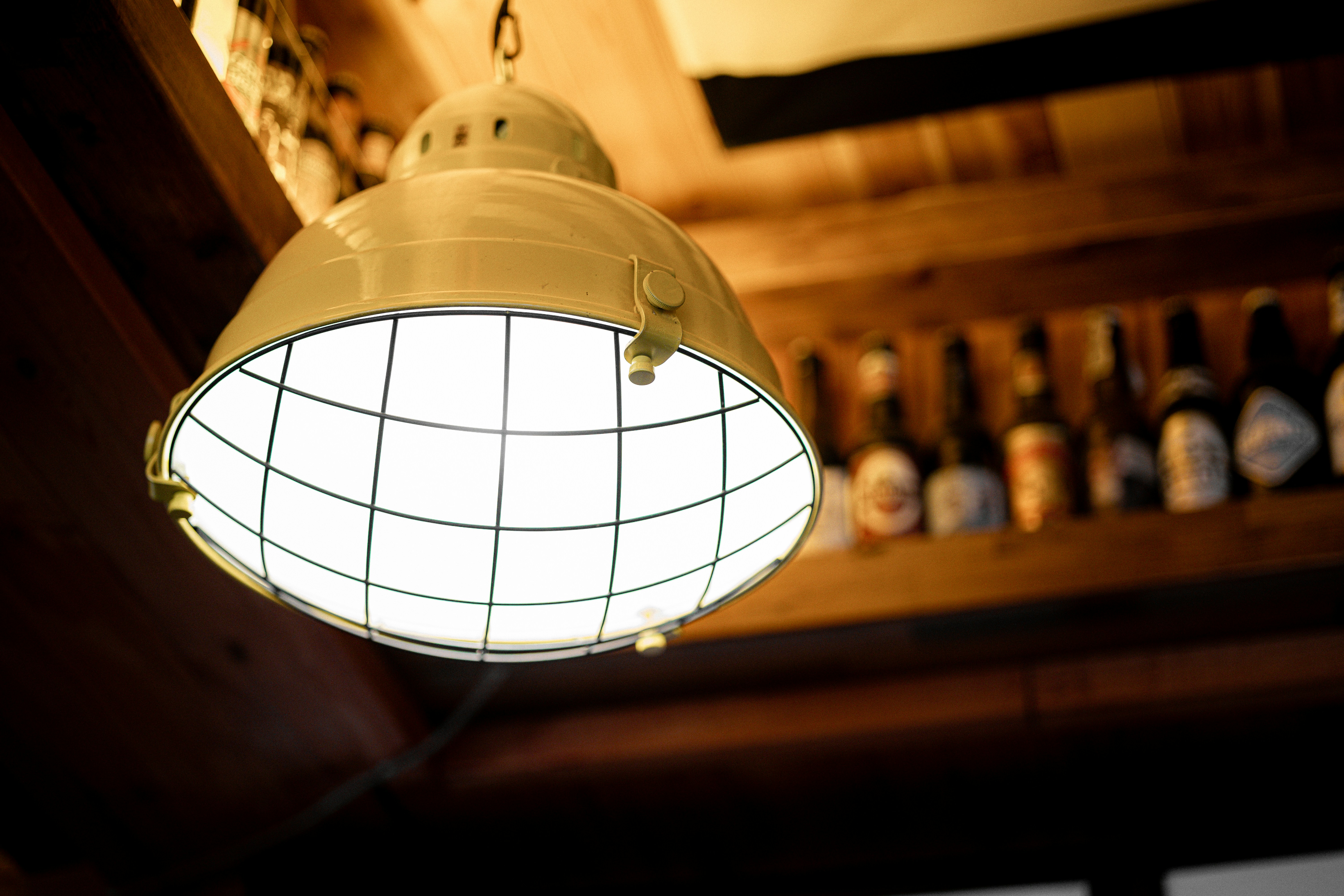 Overhead Glow: A Warm Pendant Hovering Above a Rustic Bar