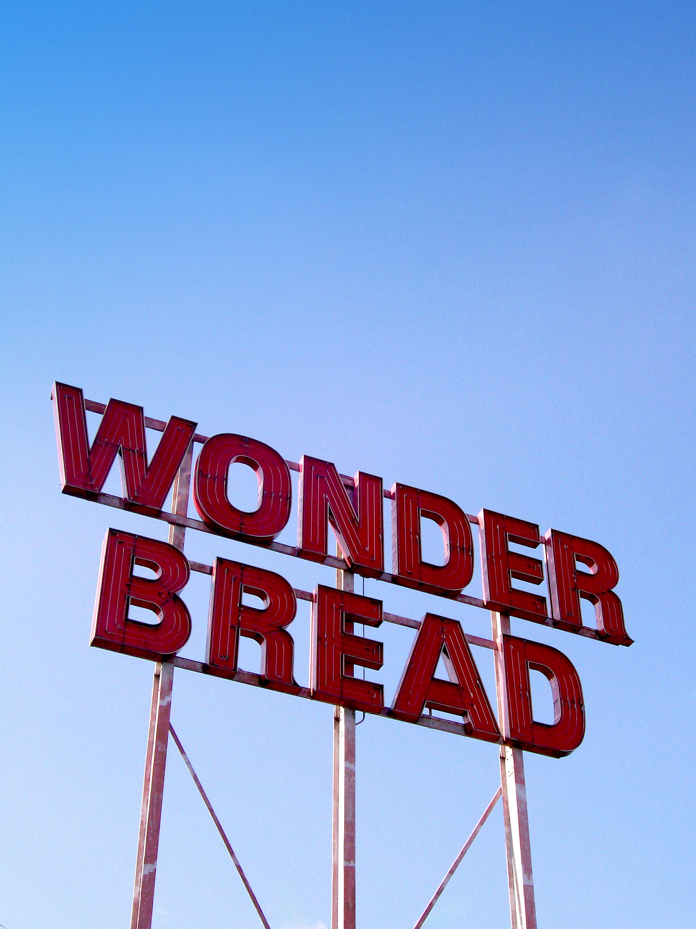 Red wonder bread sign against a clear blue sky